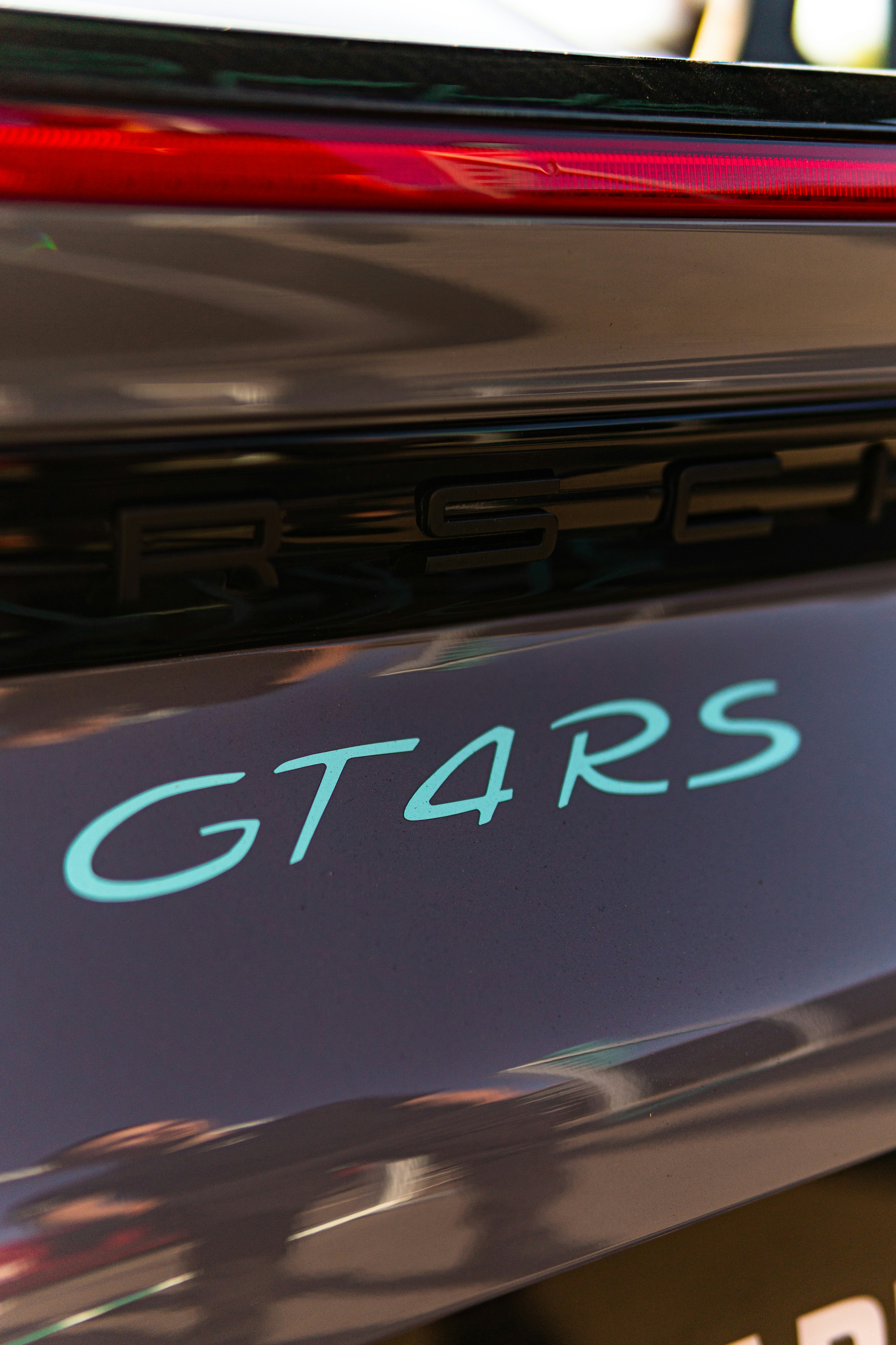 Chrome Rims and Teal GT4RS Emblem: A Porsche Close-Up