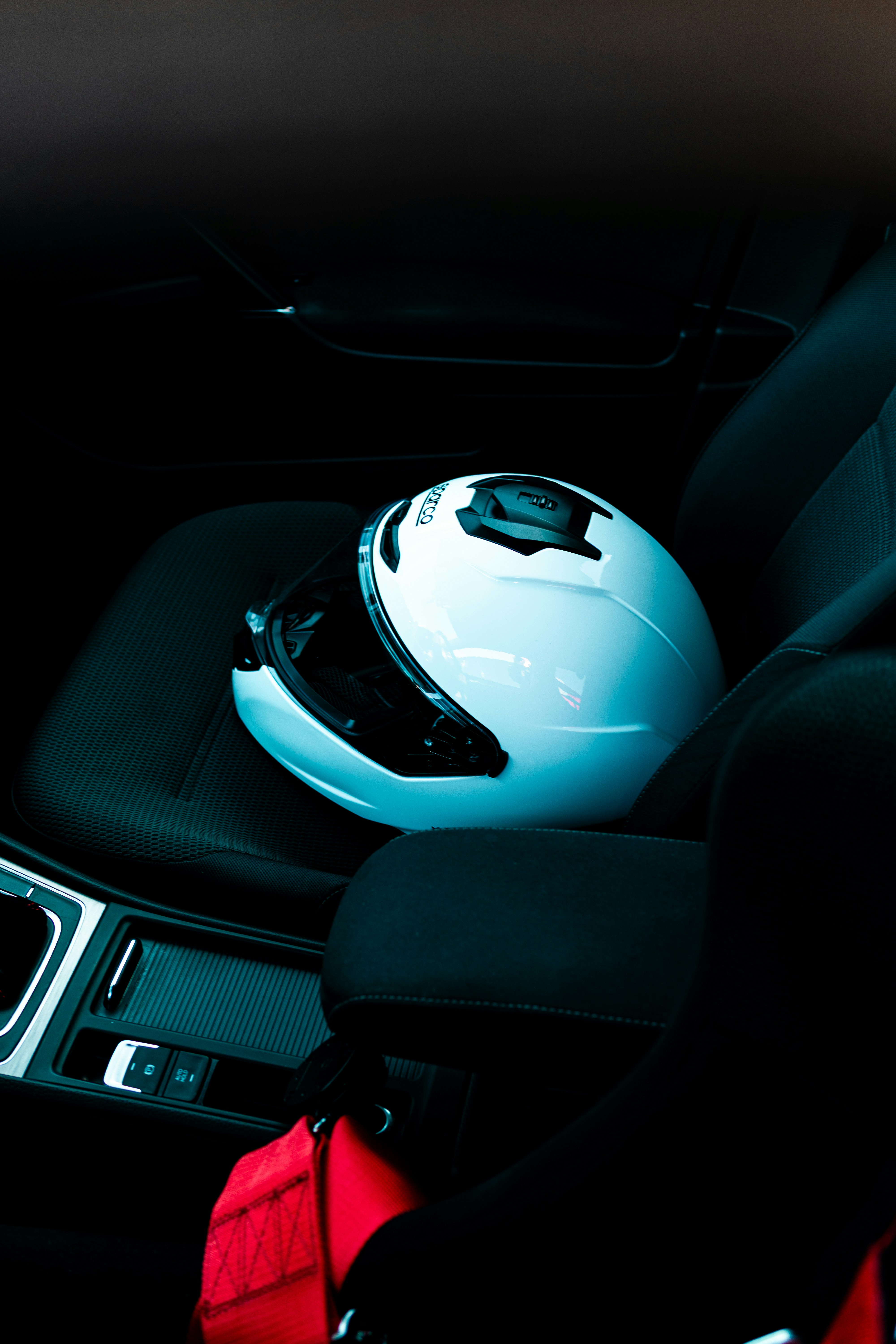 White helmet rests in car seat, dawn-blue cabin shadows