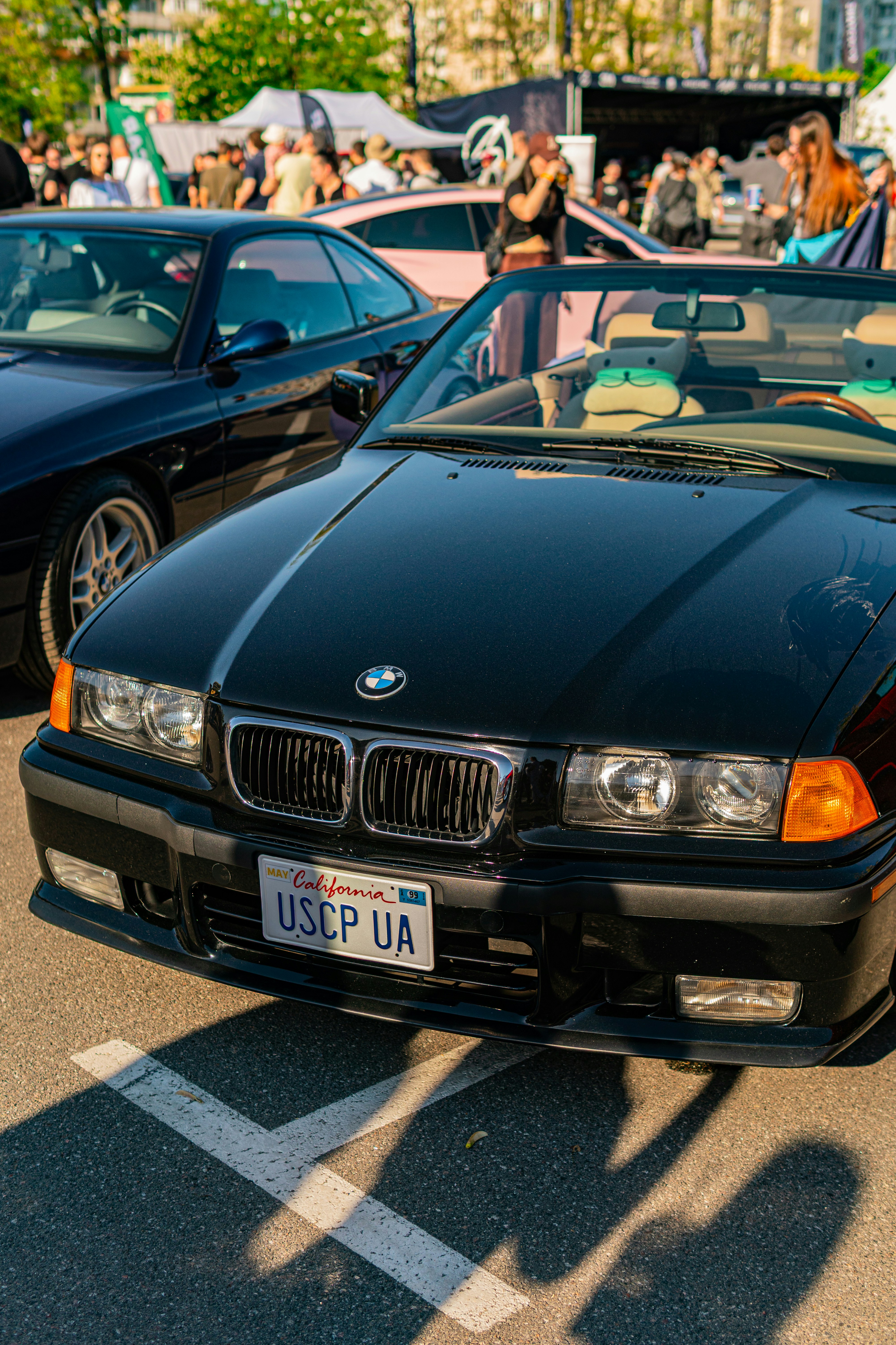 Midday Motors: A Black BMW Surrounded by a Car Show Crowd