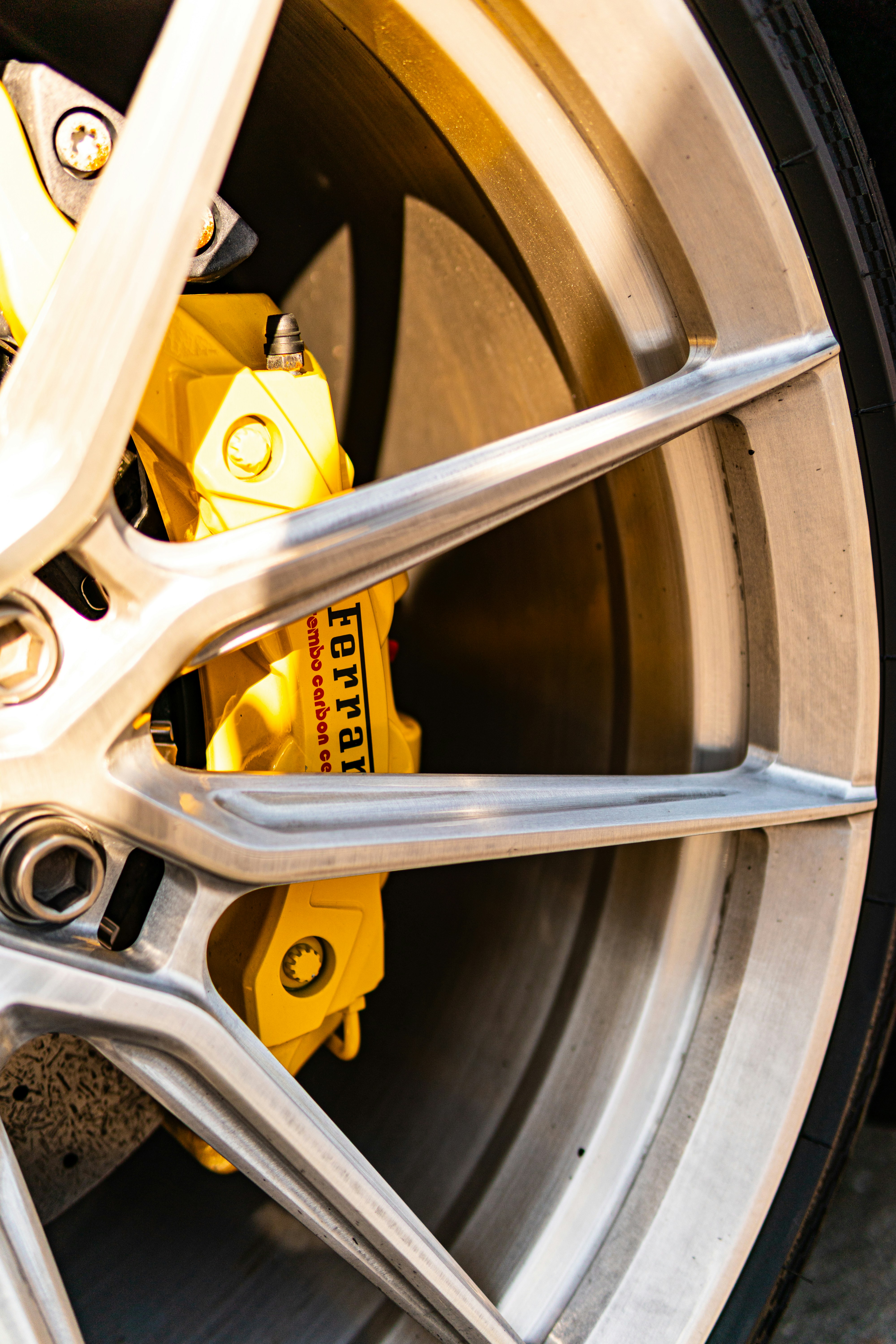 Ferrari Brilliance: A Yellow Caliper Framed by Alloy Spokes