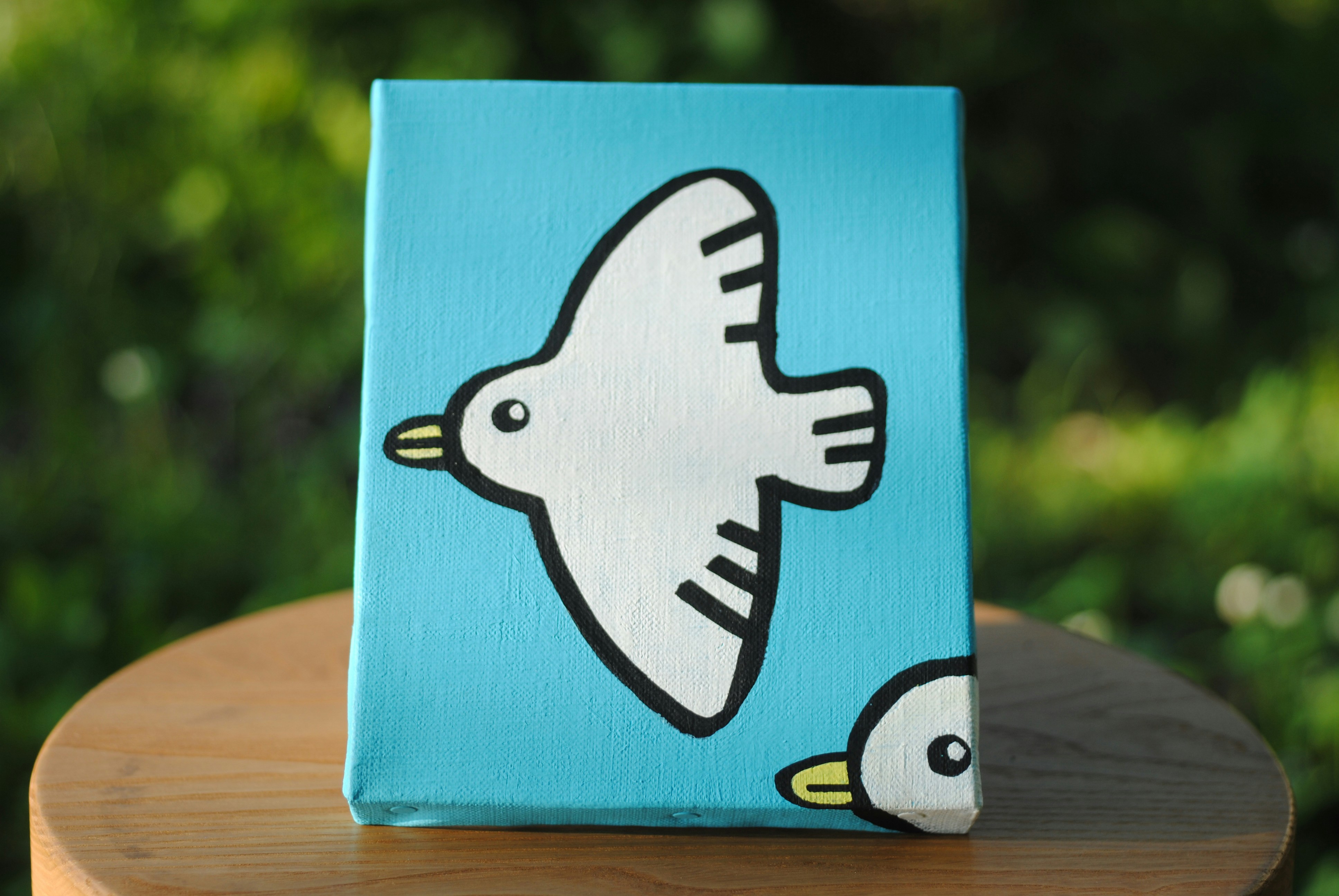 Blue Canvas Dove: Playful Illustration on a Wooden Table