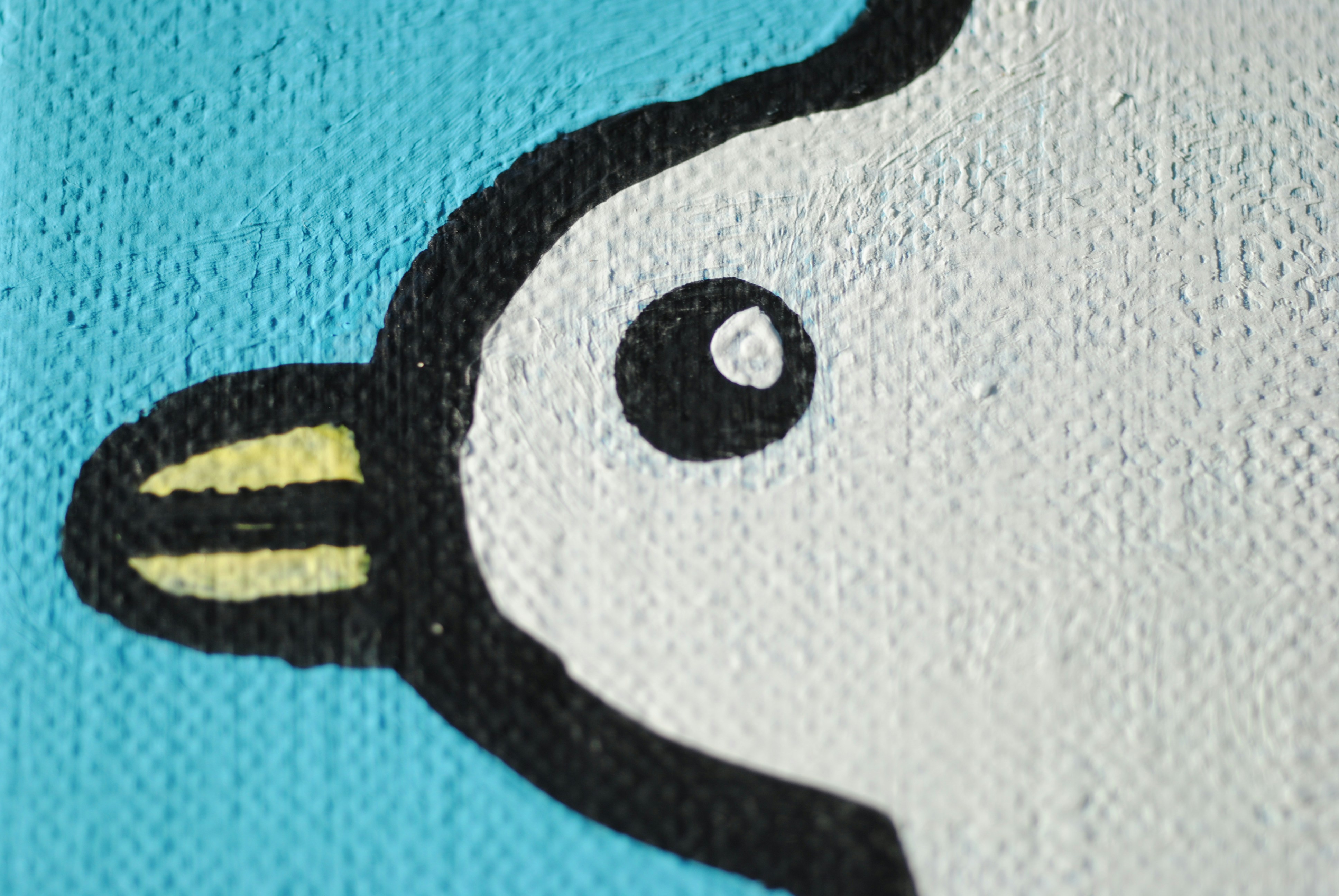 Close-up of a cartoon penguin beak and eye on textured canvas