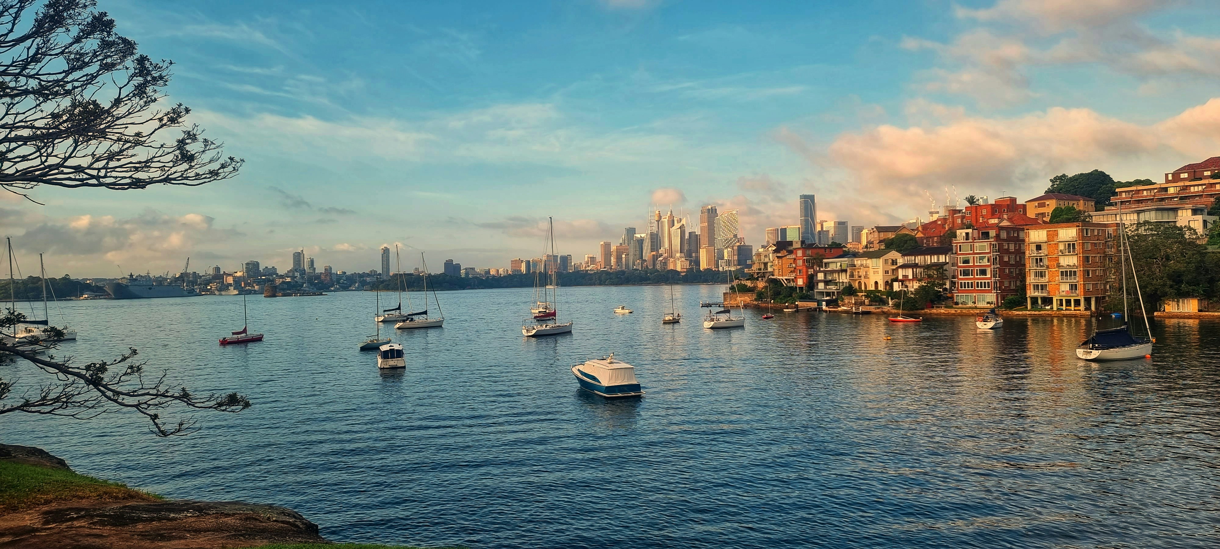 Harbor at Dusk: Boats, Bridge, and a Skyline Diffused in Warm Light