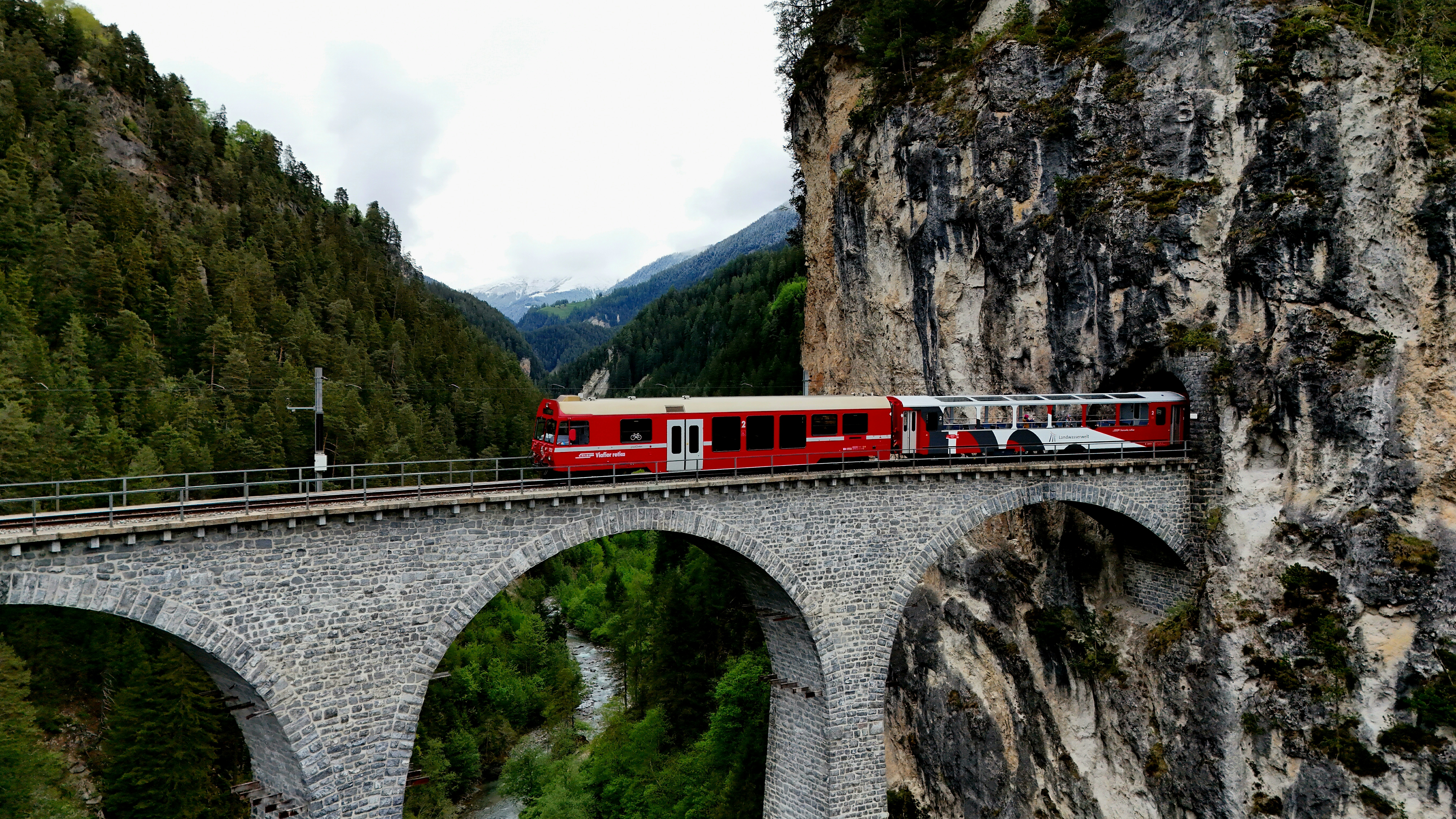 Red Locomotive Crossing a Mountain Arch