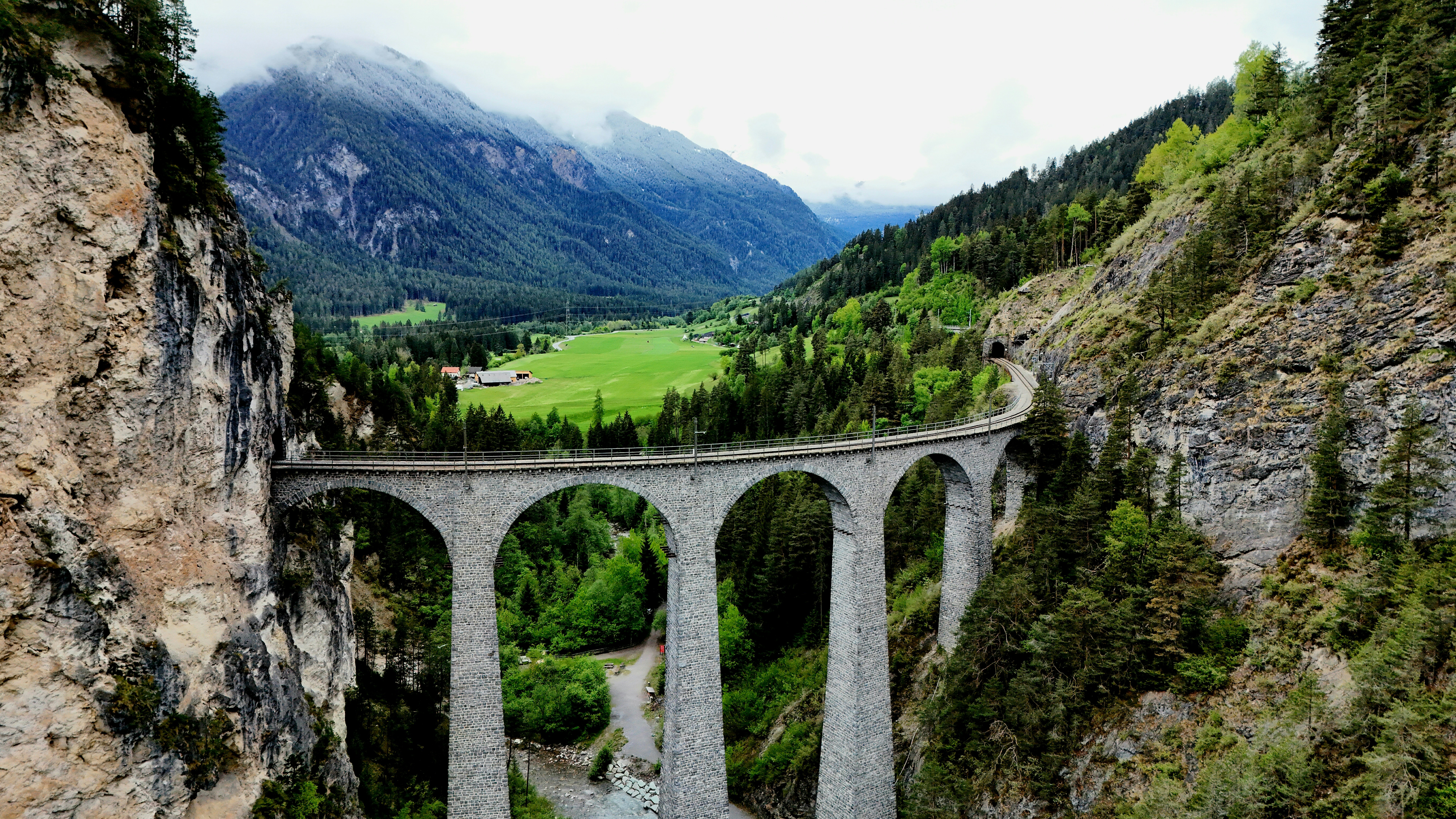 Stone Serpentine Viaduct Carving Through Alpine Gorge