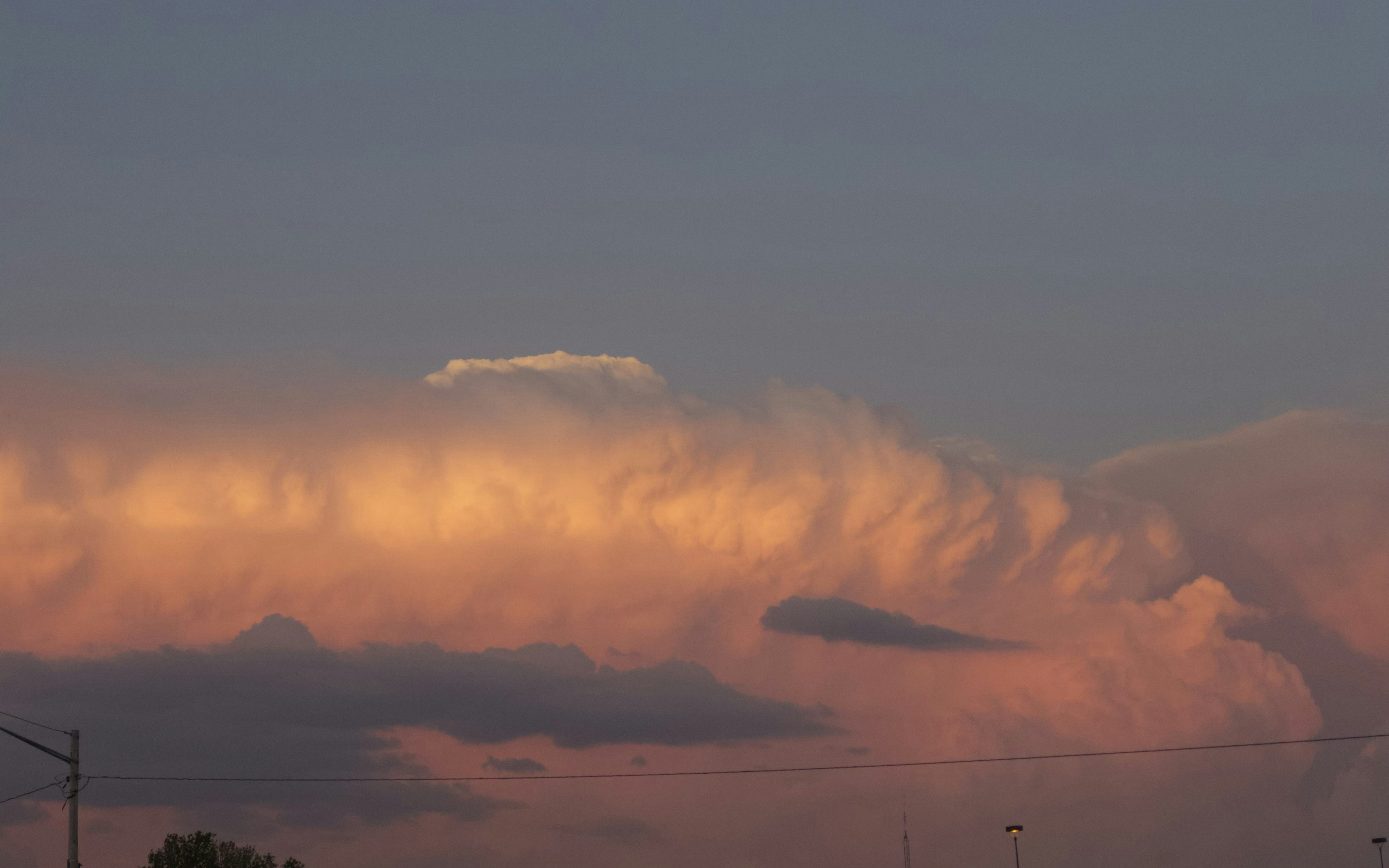 Glowing cumulus at dusk over a quiet horizon