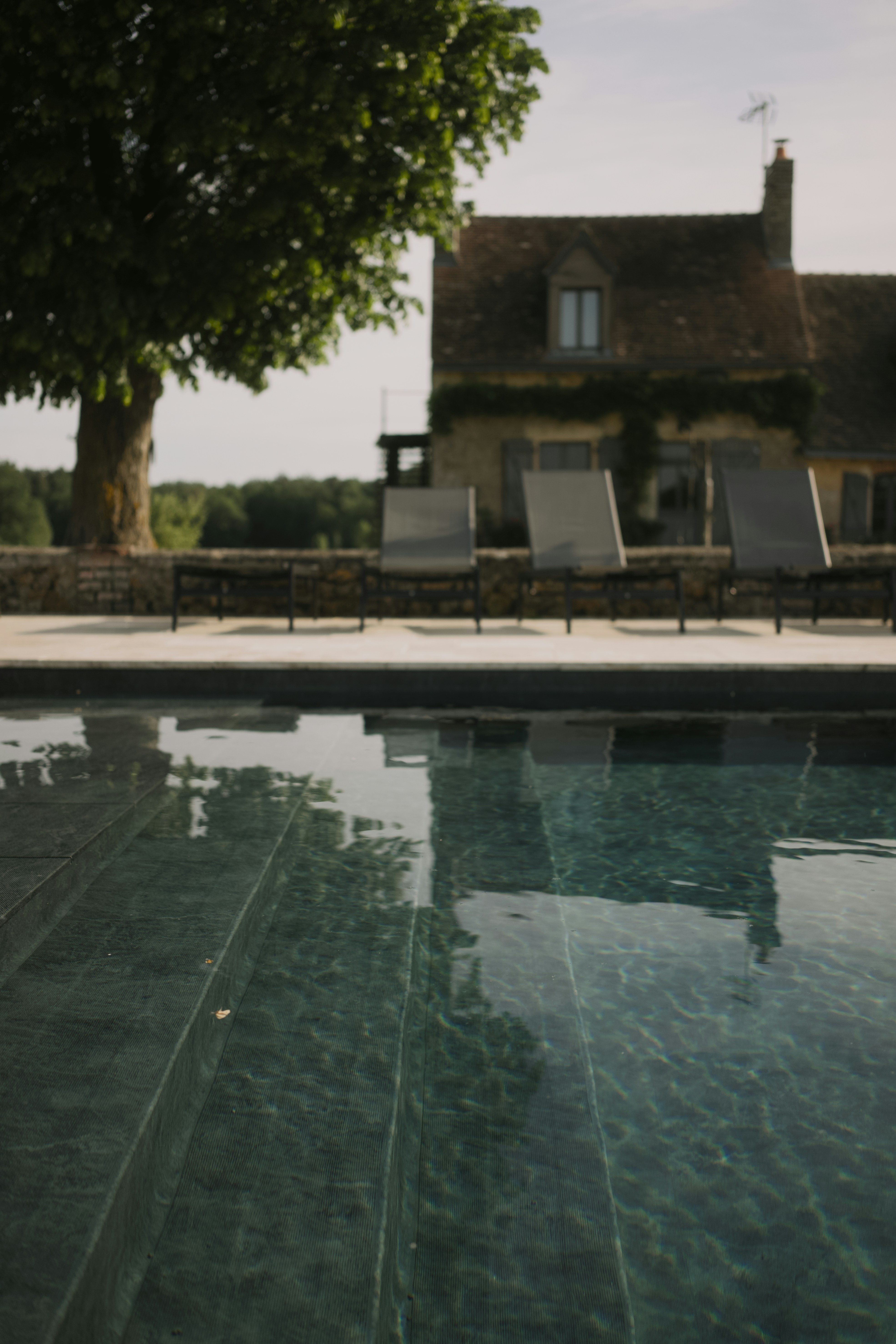 Poolside Quiet: Sunlit Terrace Behind a Rustic Home