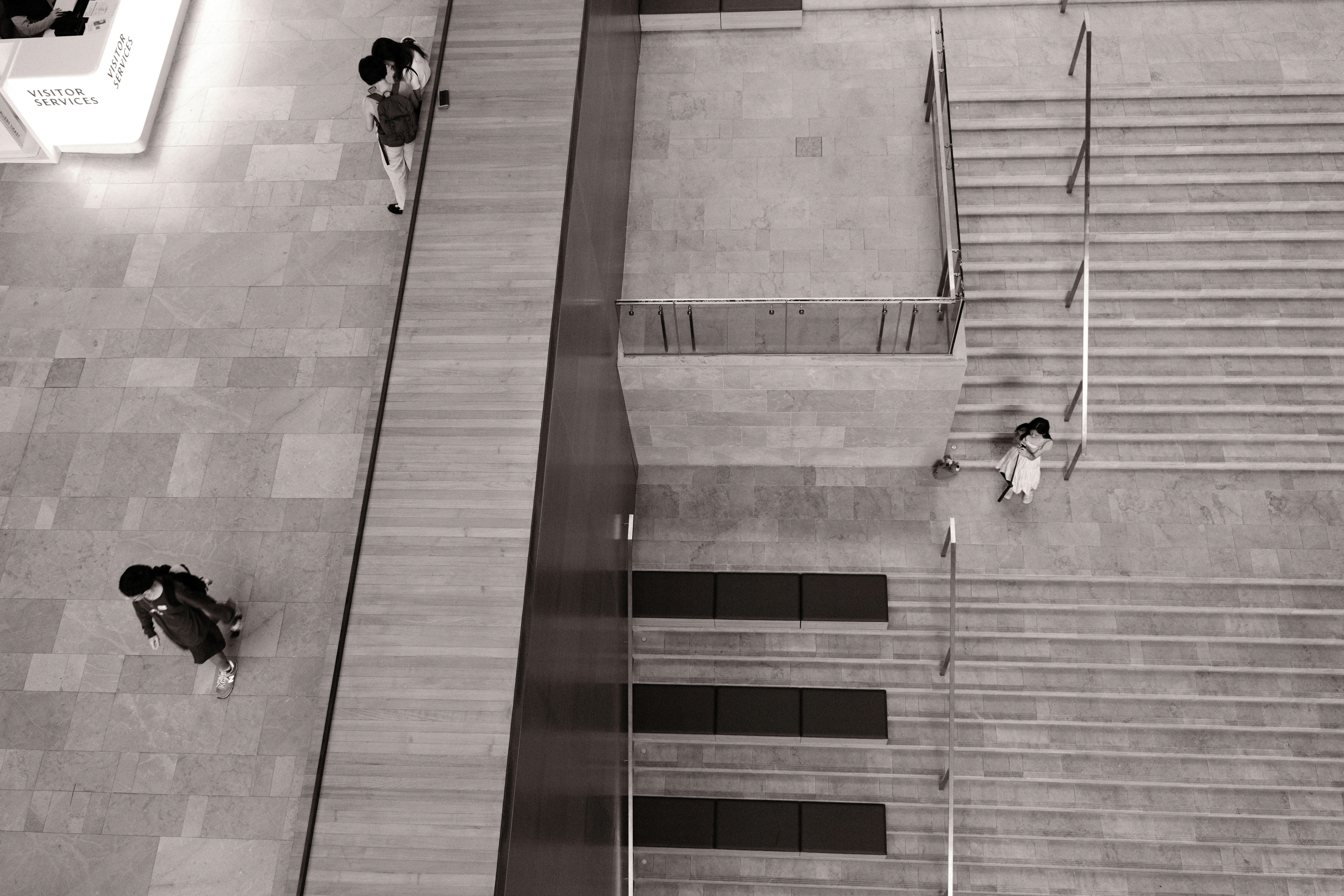 A high-angle, top-down monochrome photograph showcasing clean geometric lines and architectural symmetry inside National Gallery Singapore.