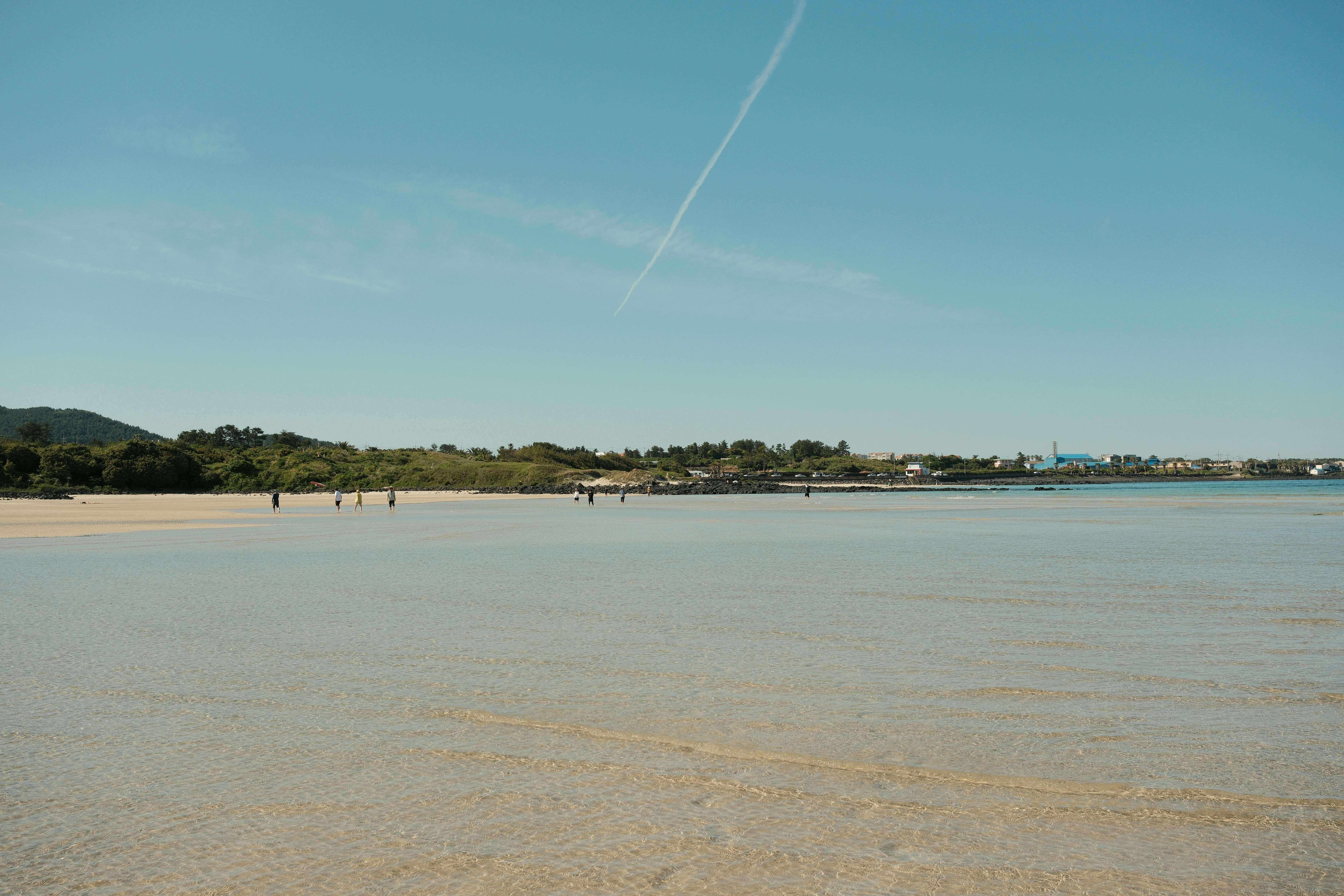 Quiet Shoreline: Clear Waters Meet a Distant Town