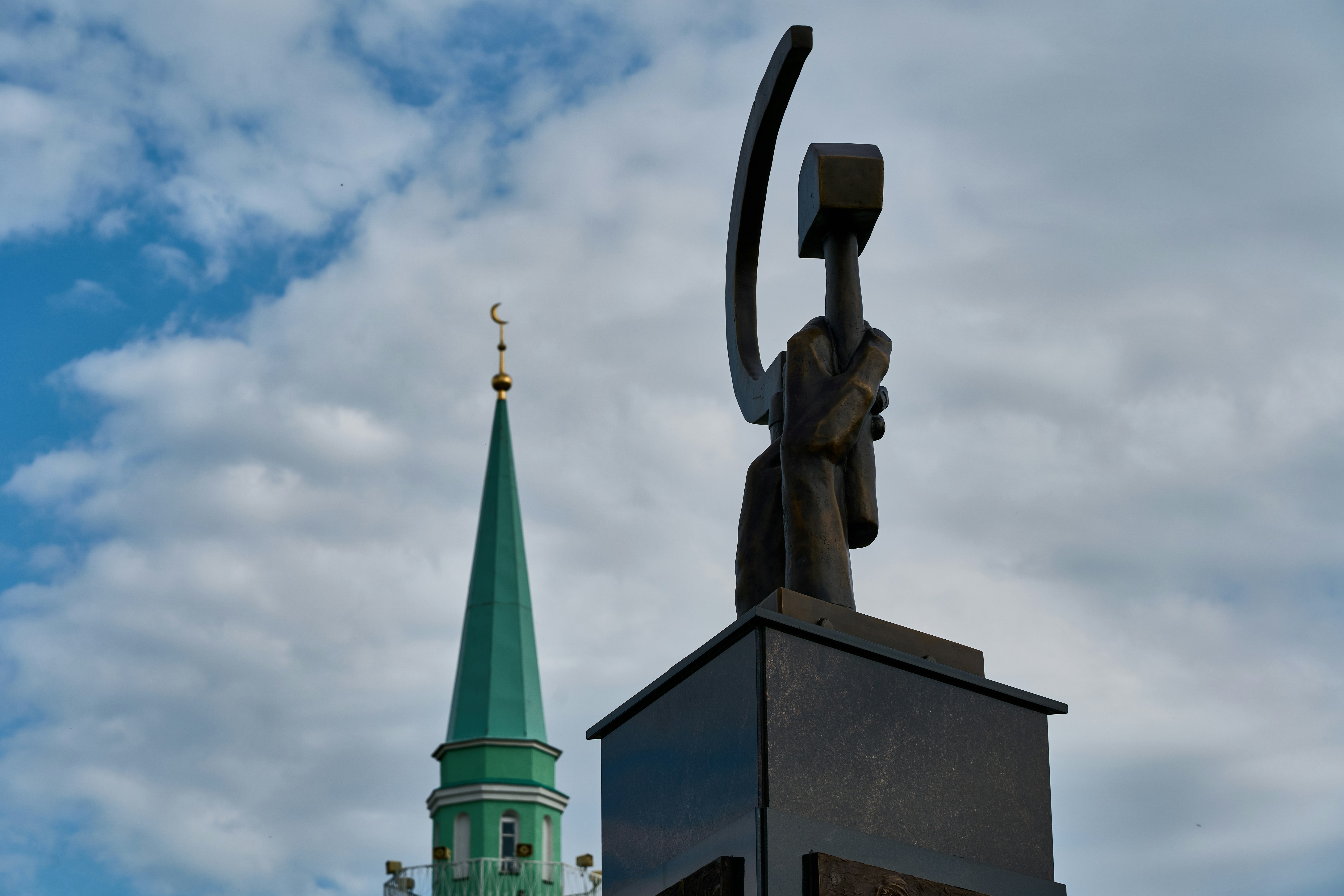 Harbinger of Progress: A Sculpted Figure Overlooking a City Spire