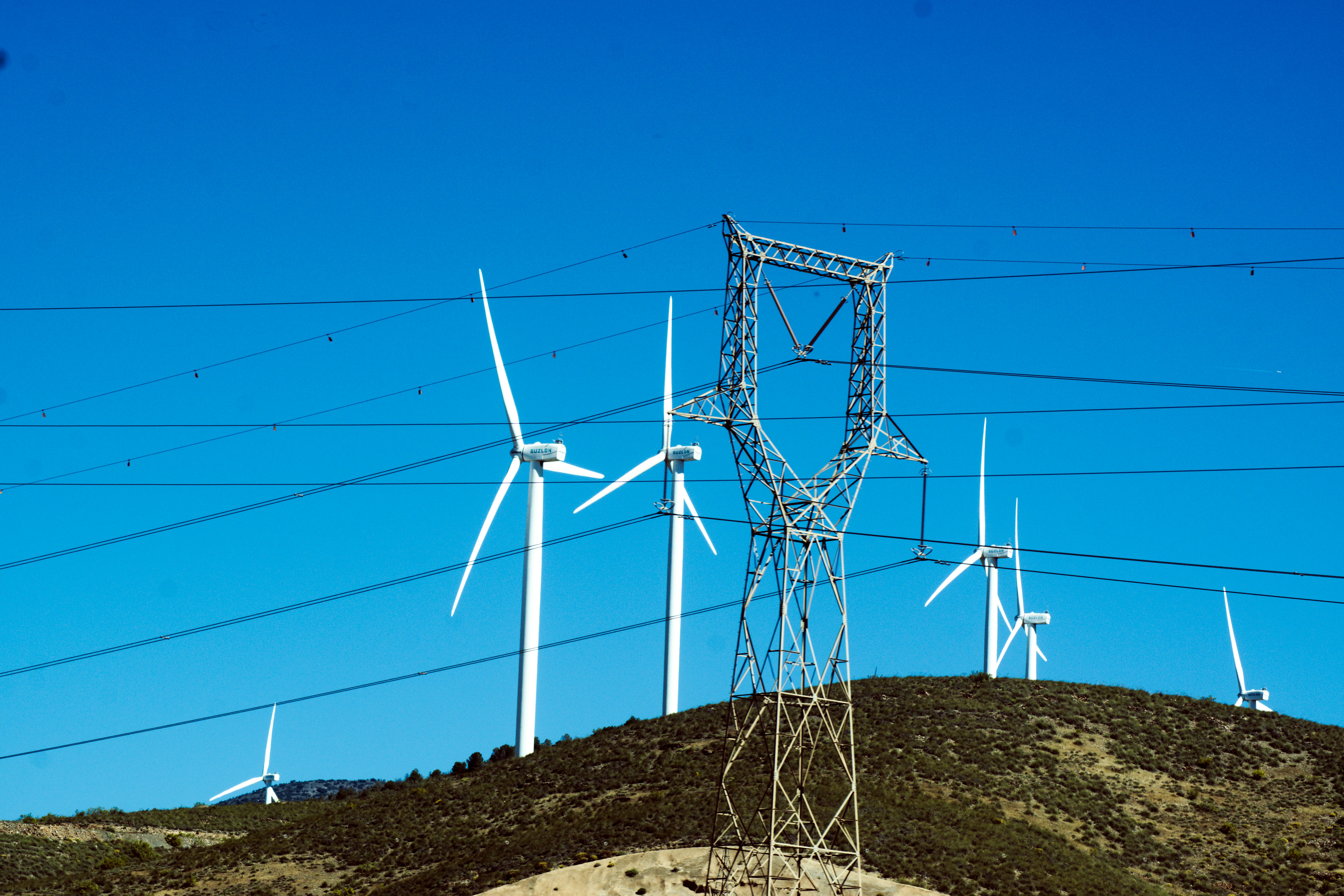 Wind Farm Silhouette: Blue Sky Over Rolling Hills and Turbines