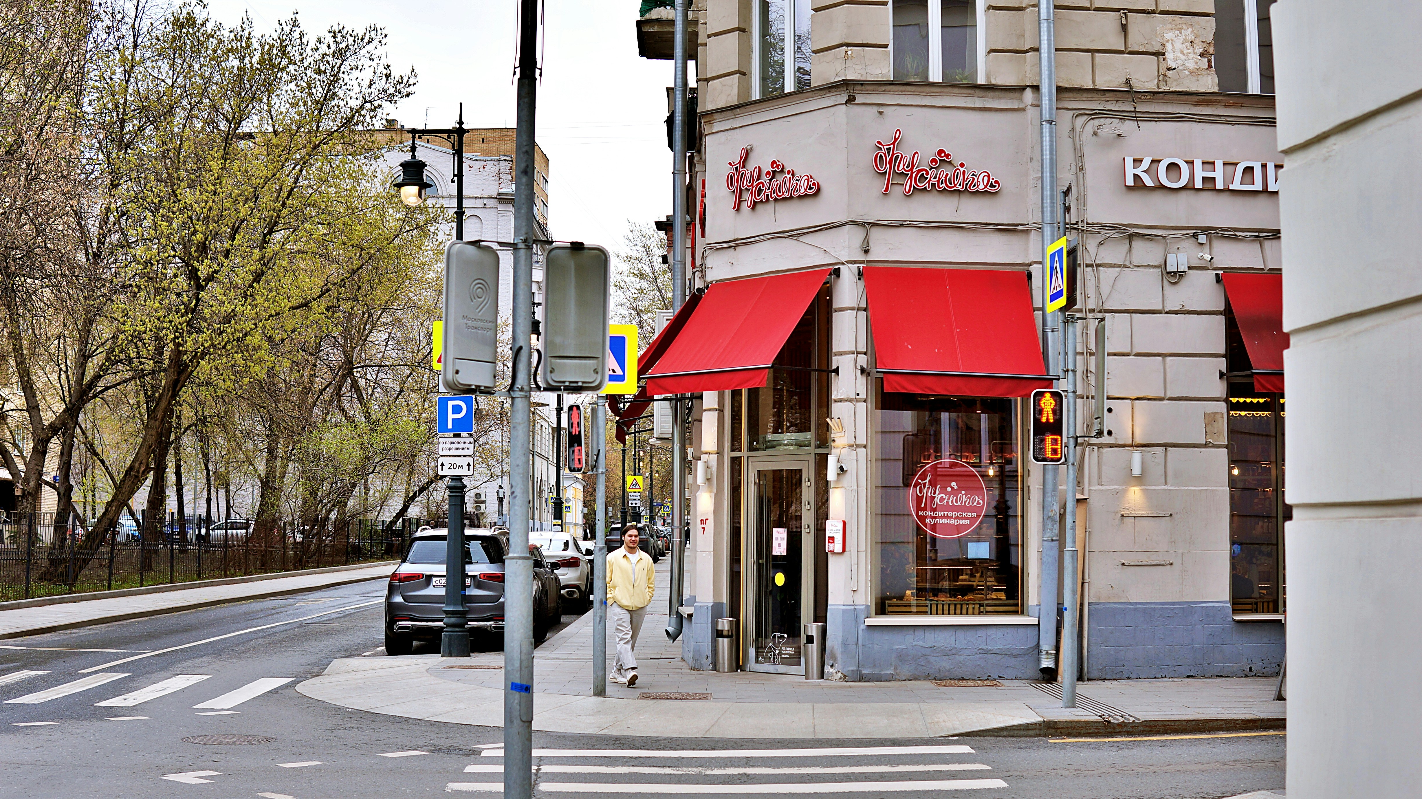 Corner Café Cornerstone: A Red Awning and Pedestrian on a City Street