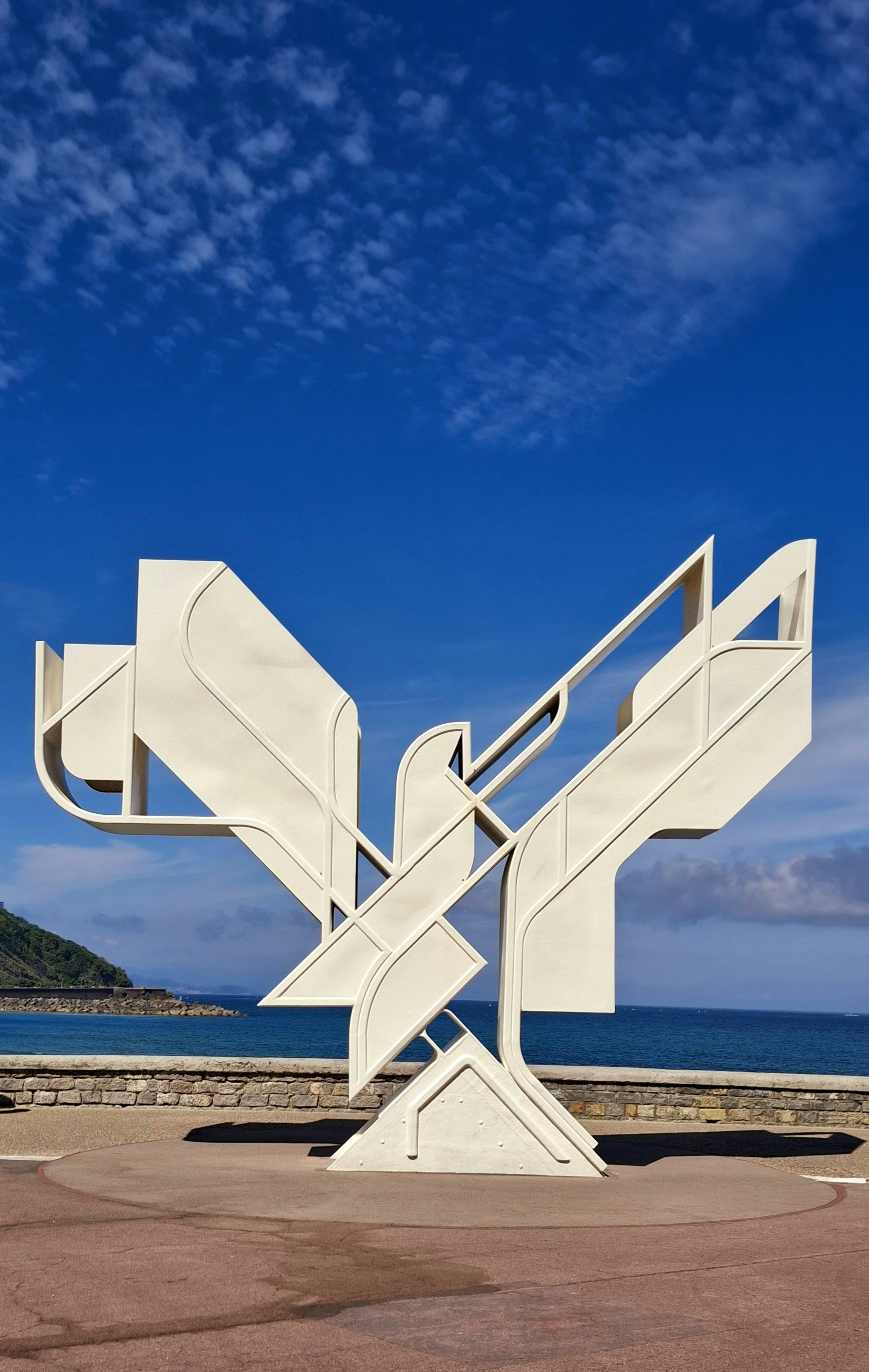 Concrete Jazz of the Sea: A Geometric Sculpture Framed by Ocean Blues