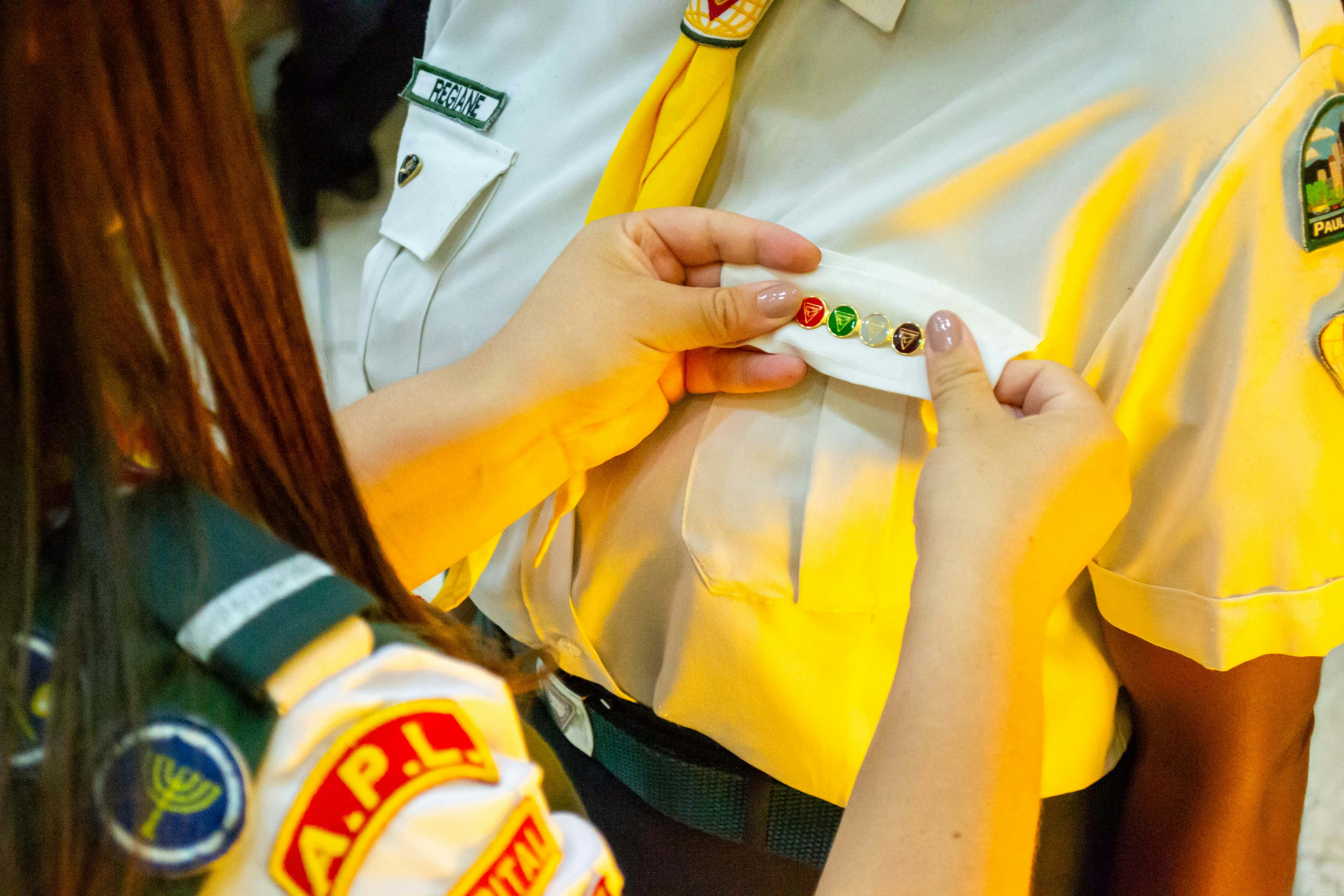 Hands attaching colorful badges to a uniform shirt. photo – Free Award ...