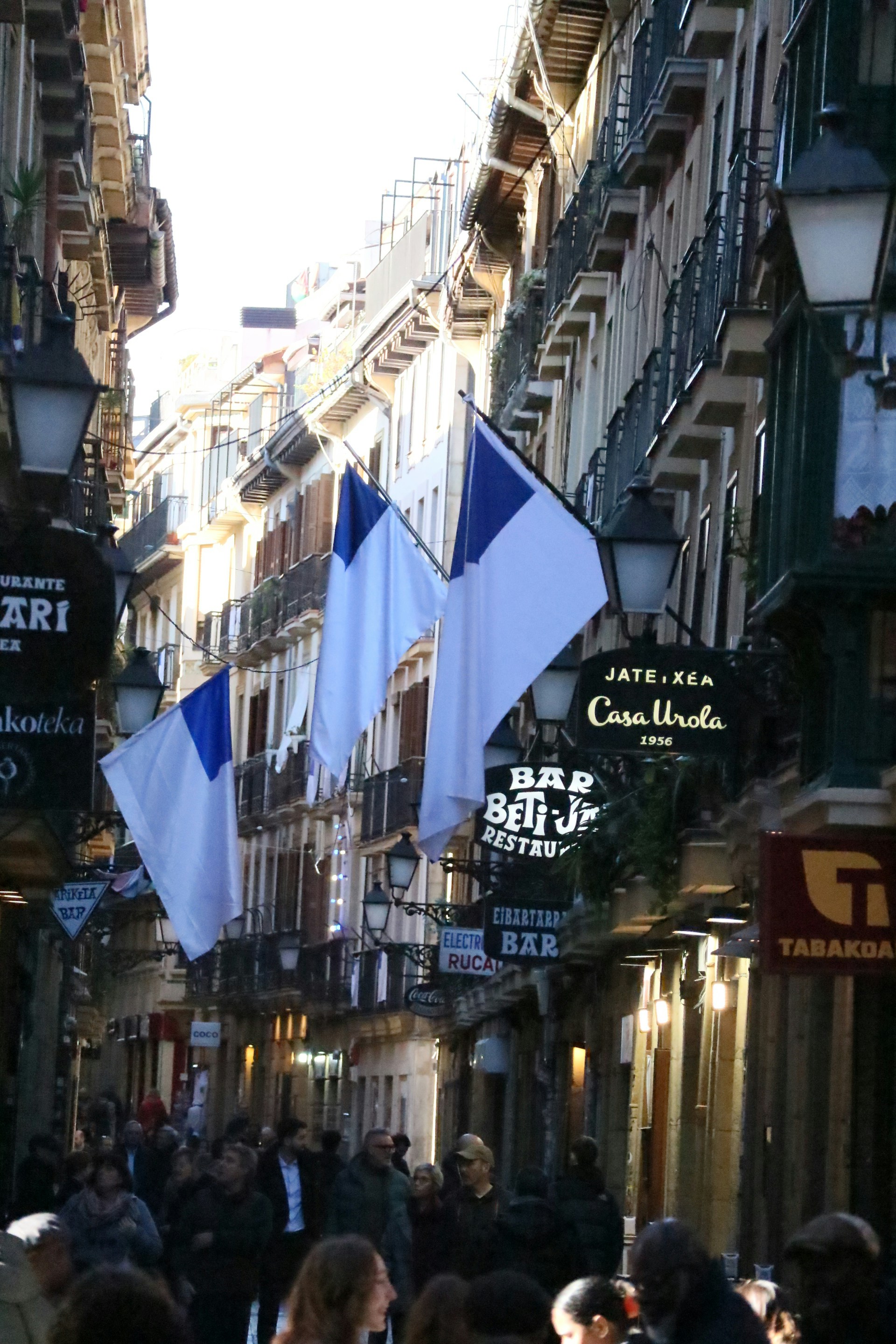 Flagged Calle: City Street Damp with Evening Glow and Blue Pennants