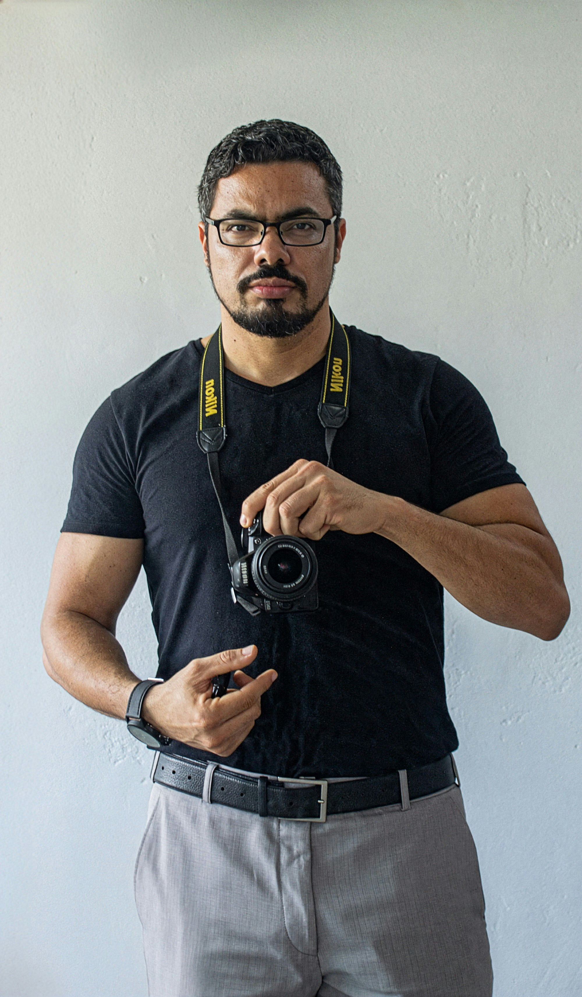 Portrait with a Lens of Focus: The Camera Clutched by a Confident Photographer