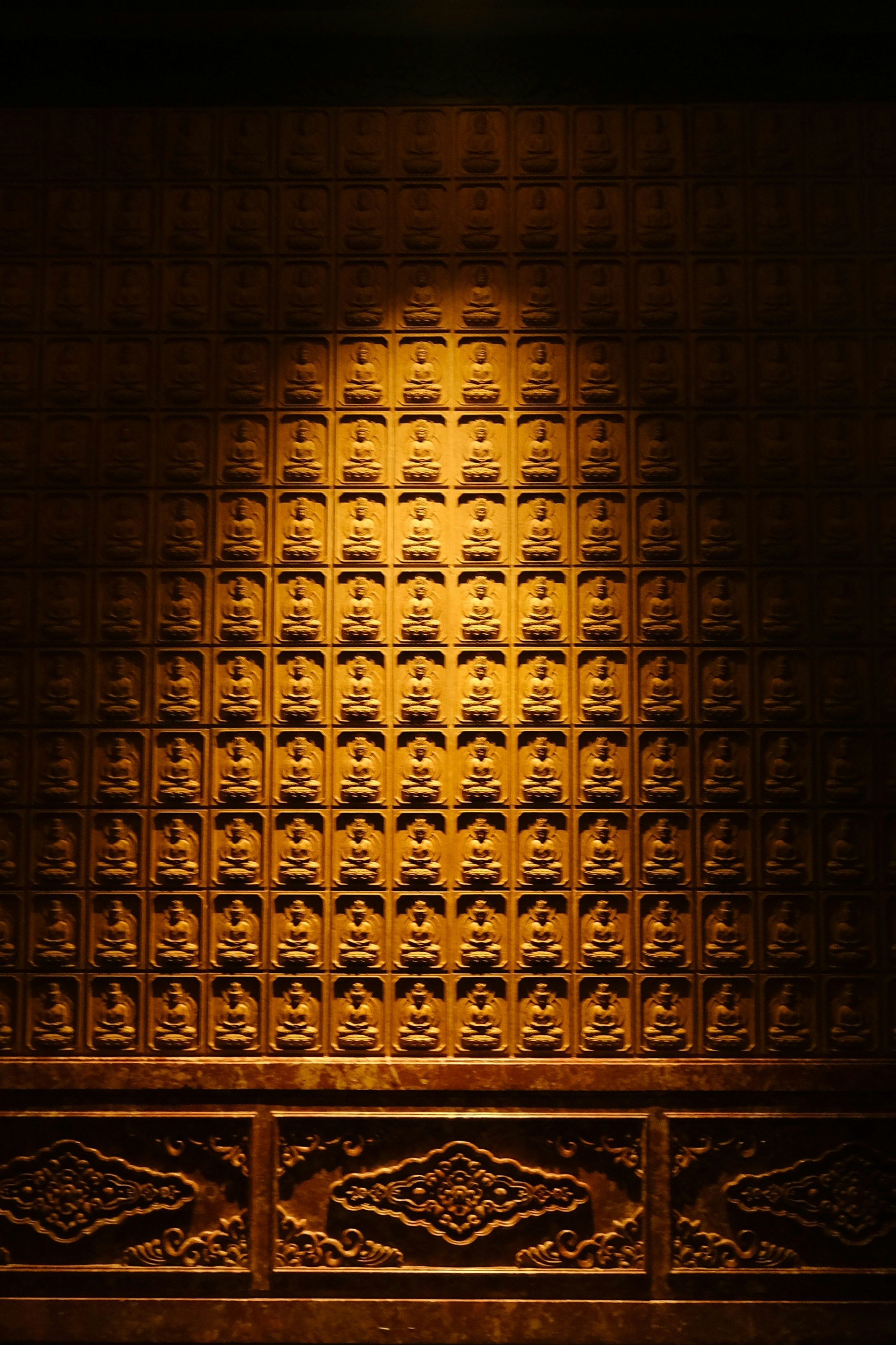 Amber Chamber: Repetitive Buddhas in a Warm Gallery