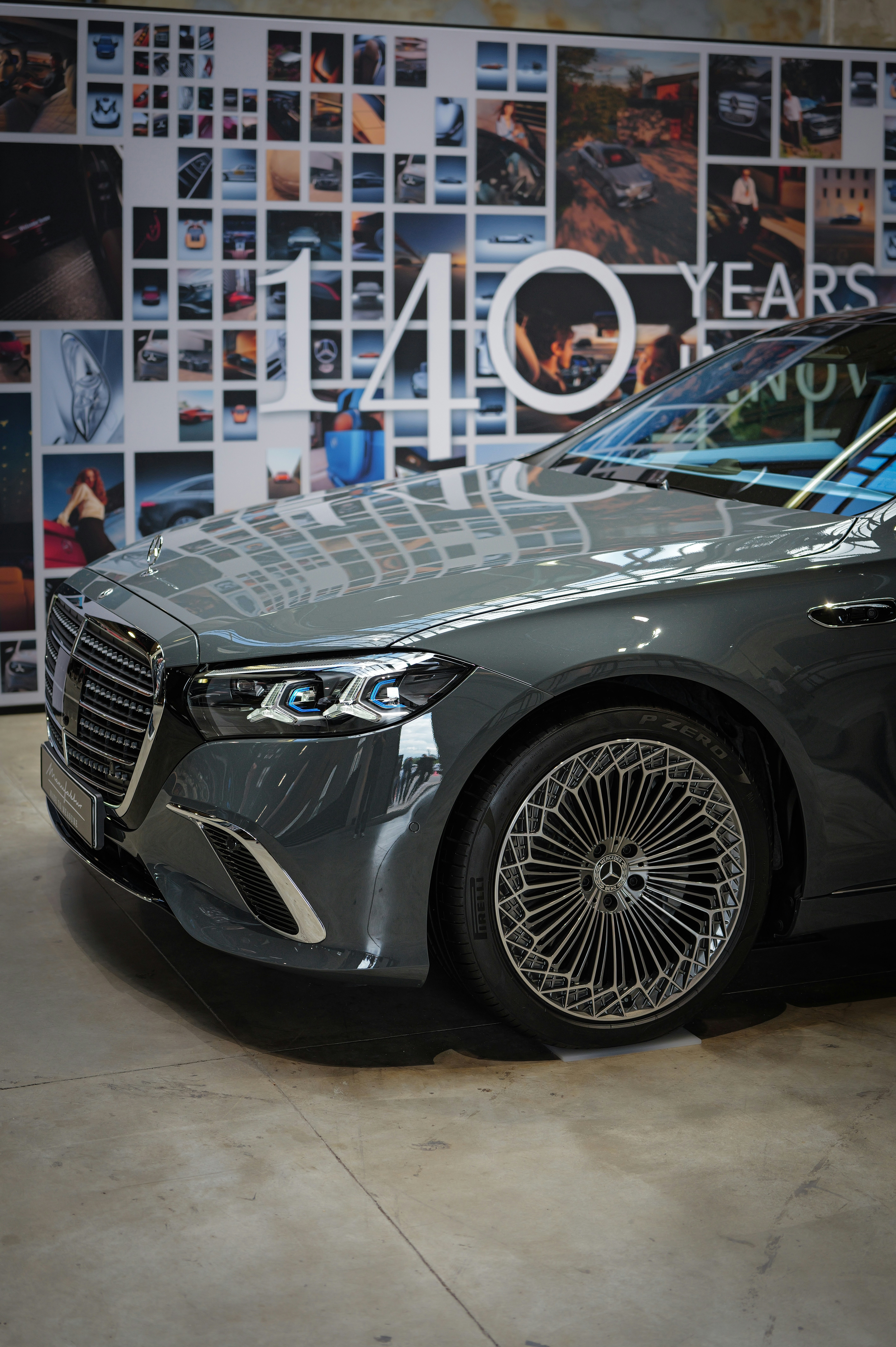 Front-Quarter of a Luxury sedan at a 140-year celebration backdrop