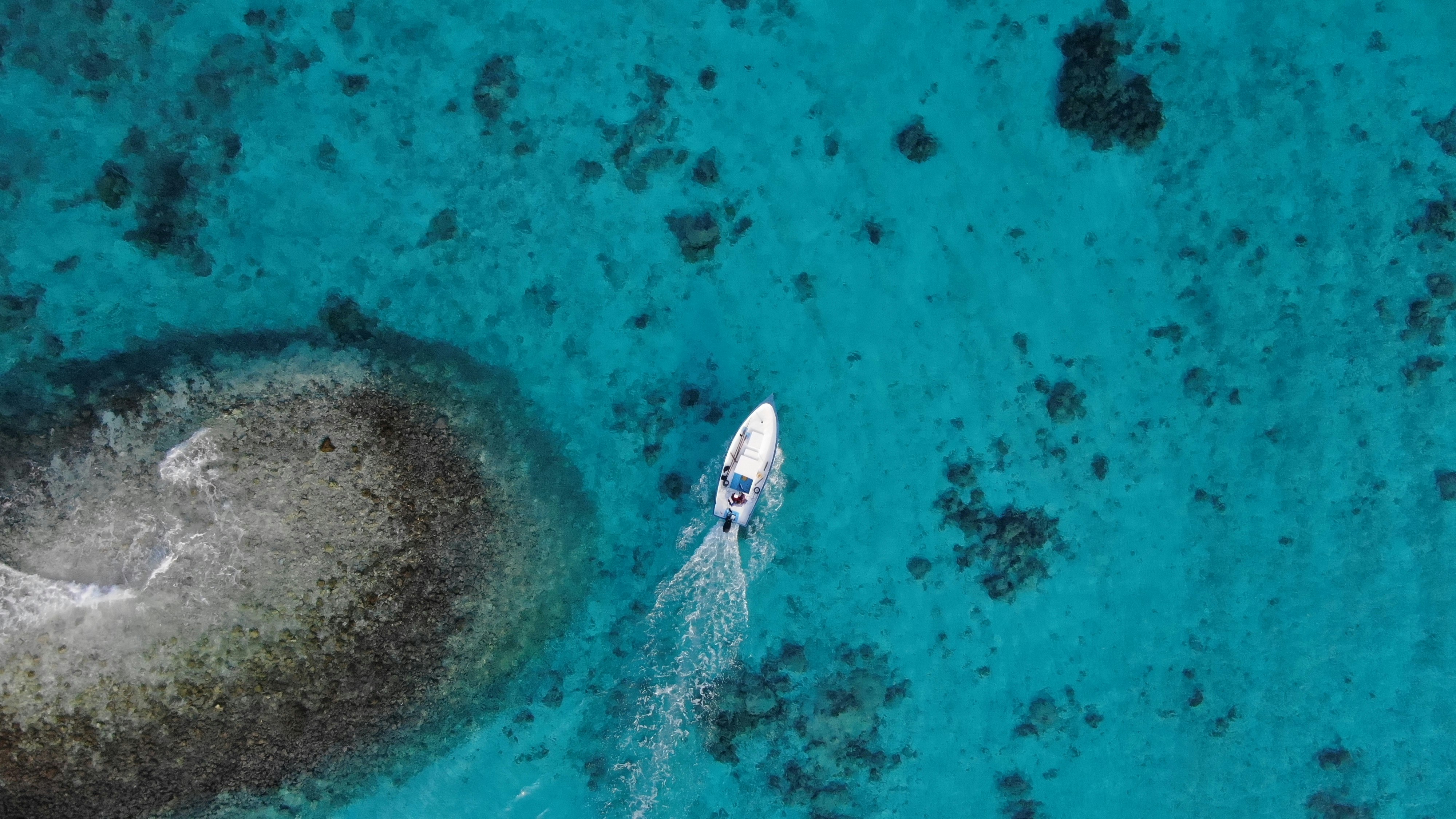 Blue Abyss: A Solo Boat Traces a Narrow Path Through Turquoise Depths