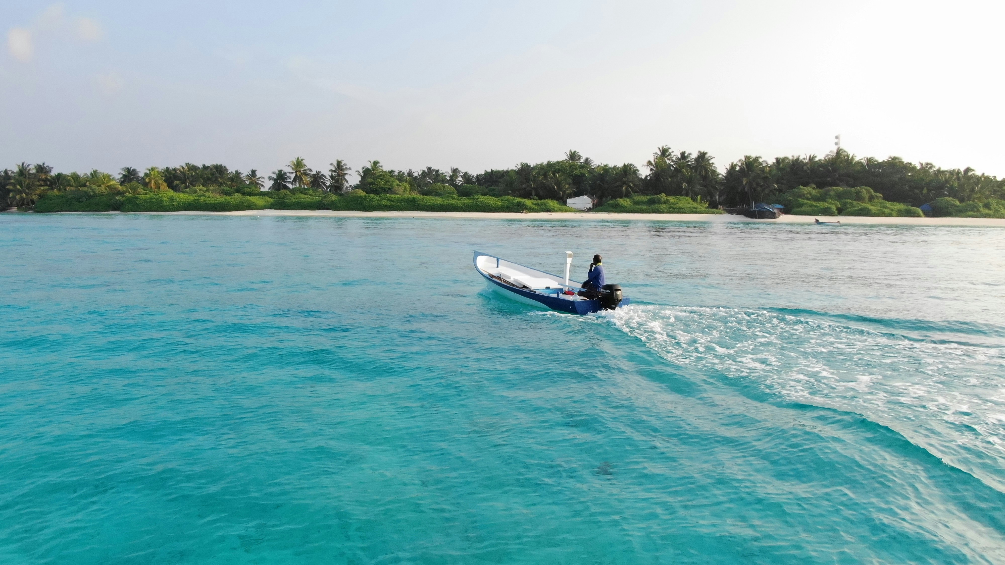 Blue Wake: A solitary speedboat glides across turquoise tropical waters