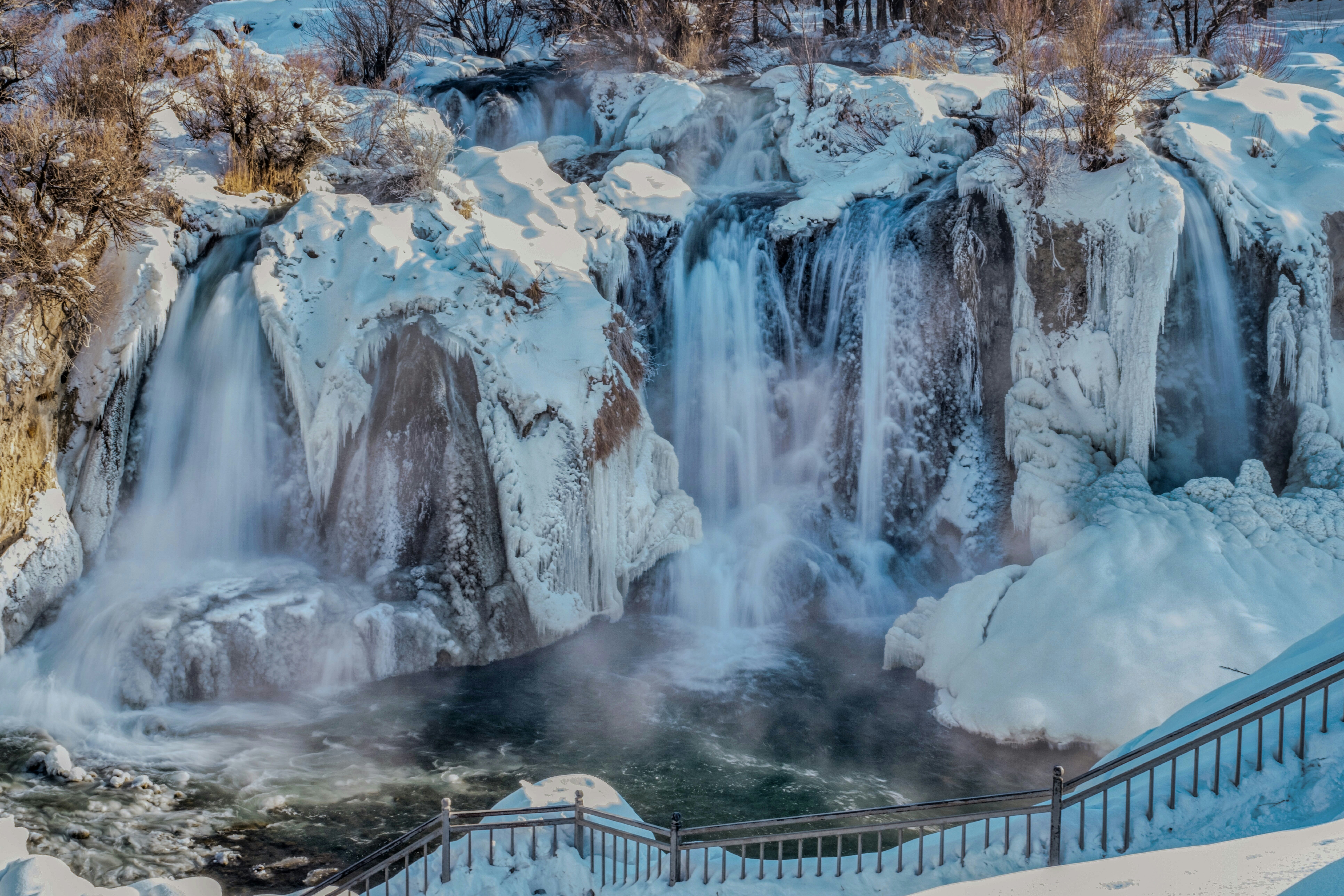 Icy Cascade at the Edge: Snow-Capped Gorge and Curved Walkway