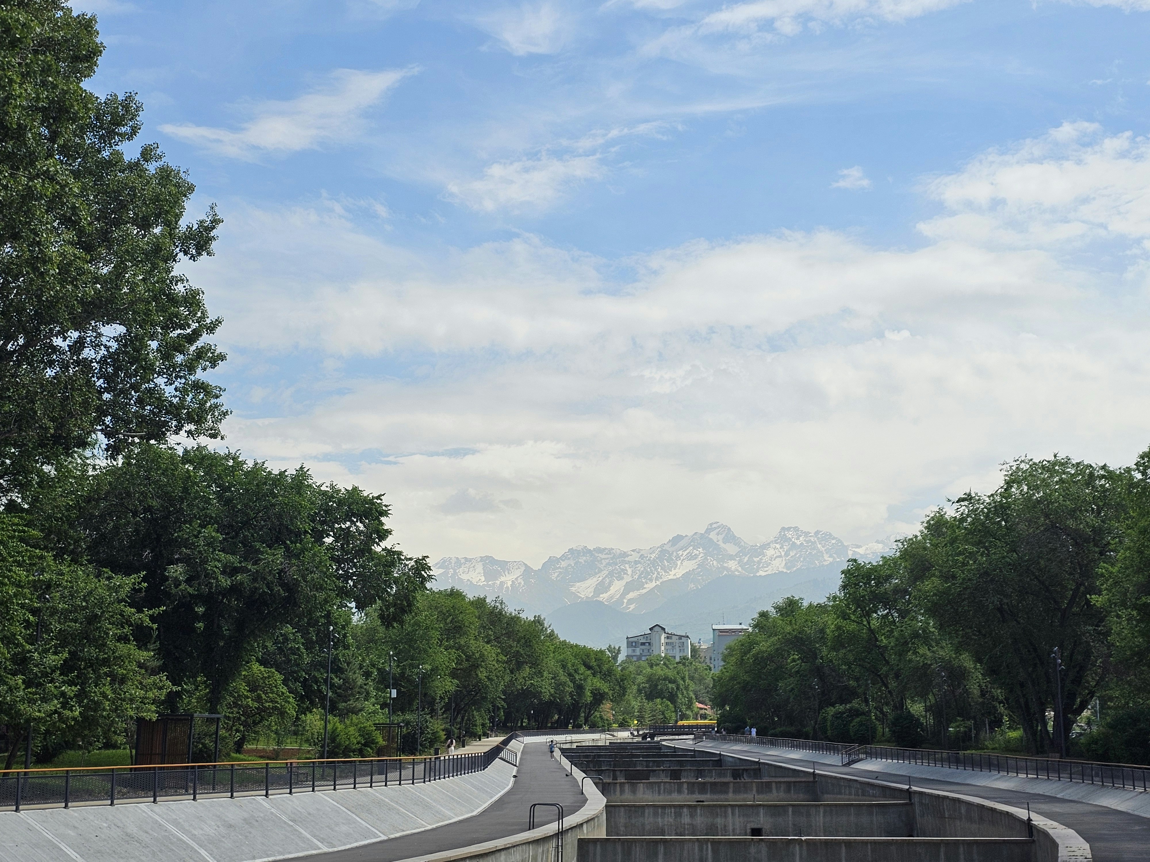 City canal leading to distant snow-capped peaks