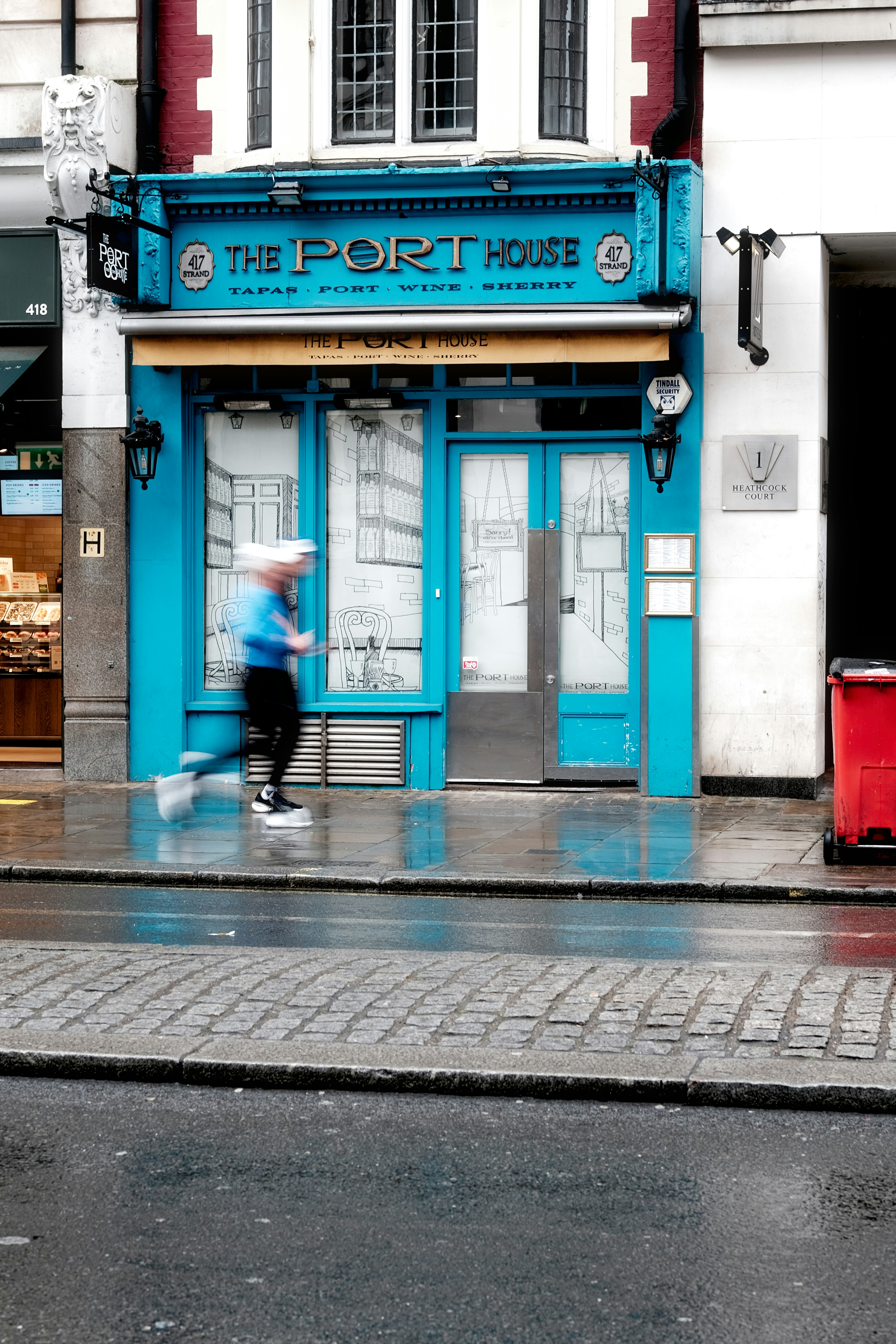 Blue doorway heartbeat: the Port House on a rain-slick street