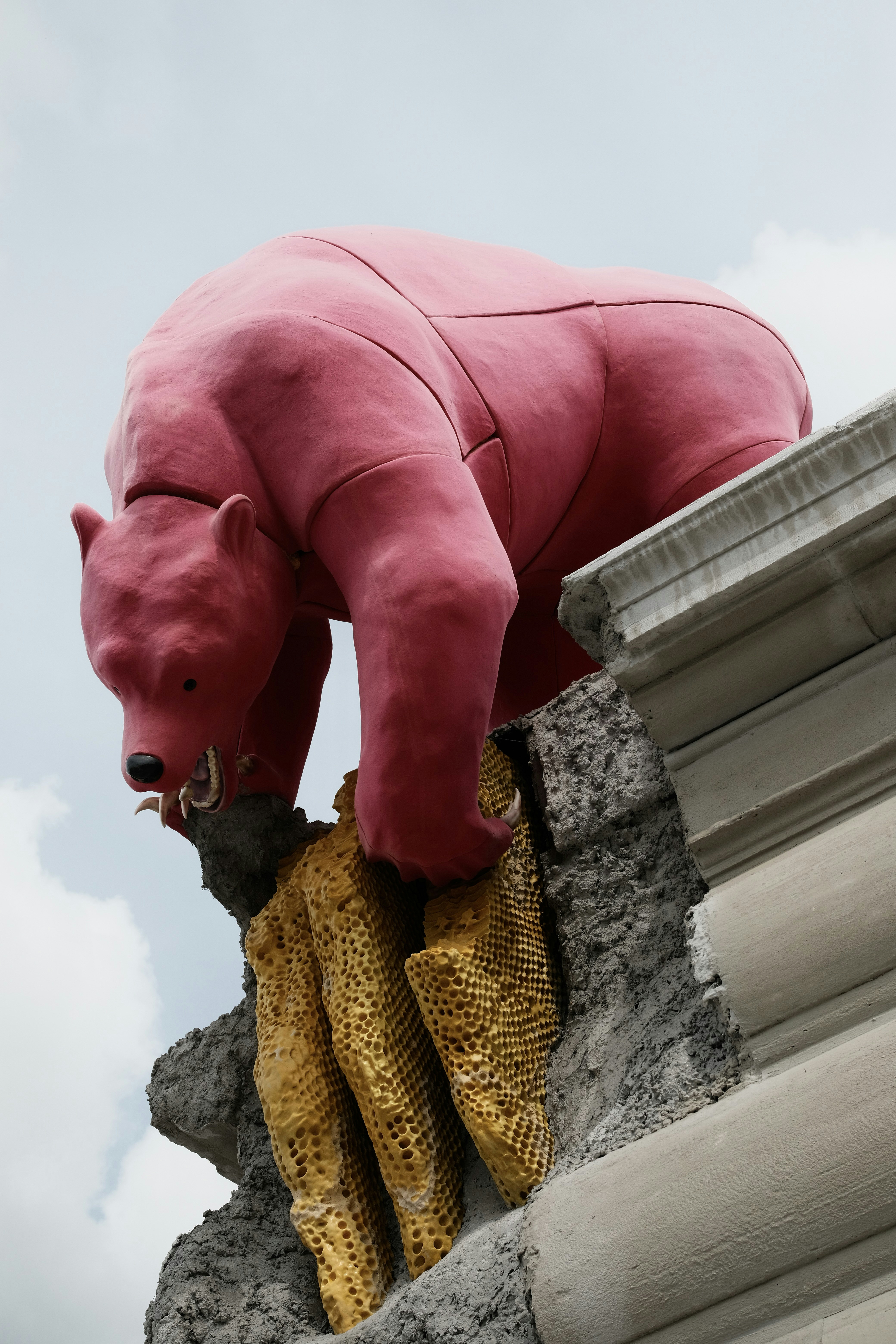 A Pink Creature Dangling from Ruins Above the City