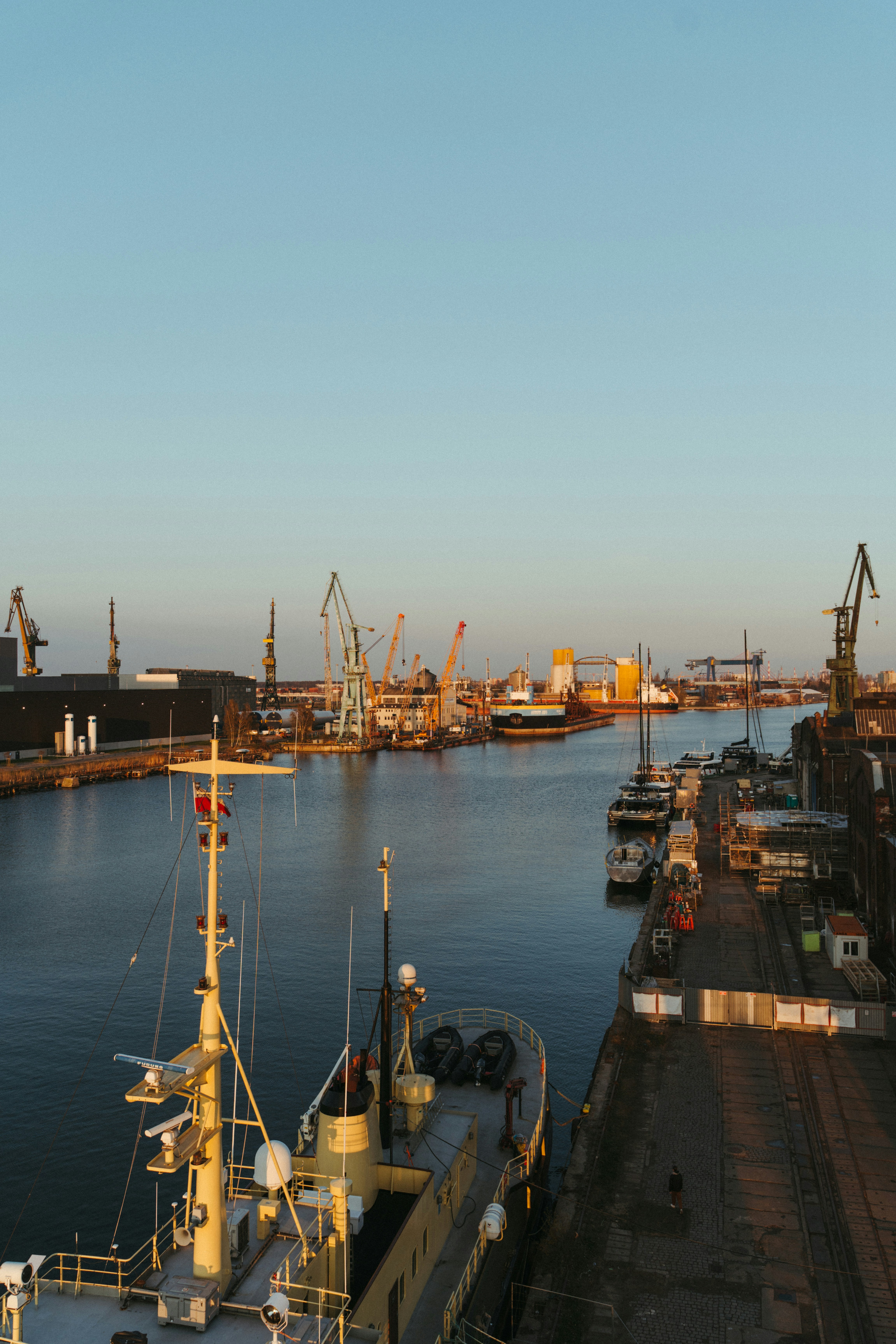 Industrial Harbor at Dusk: Cranes, Boats, and Calm Water