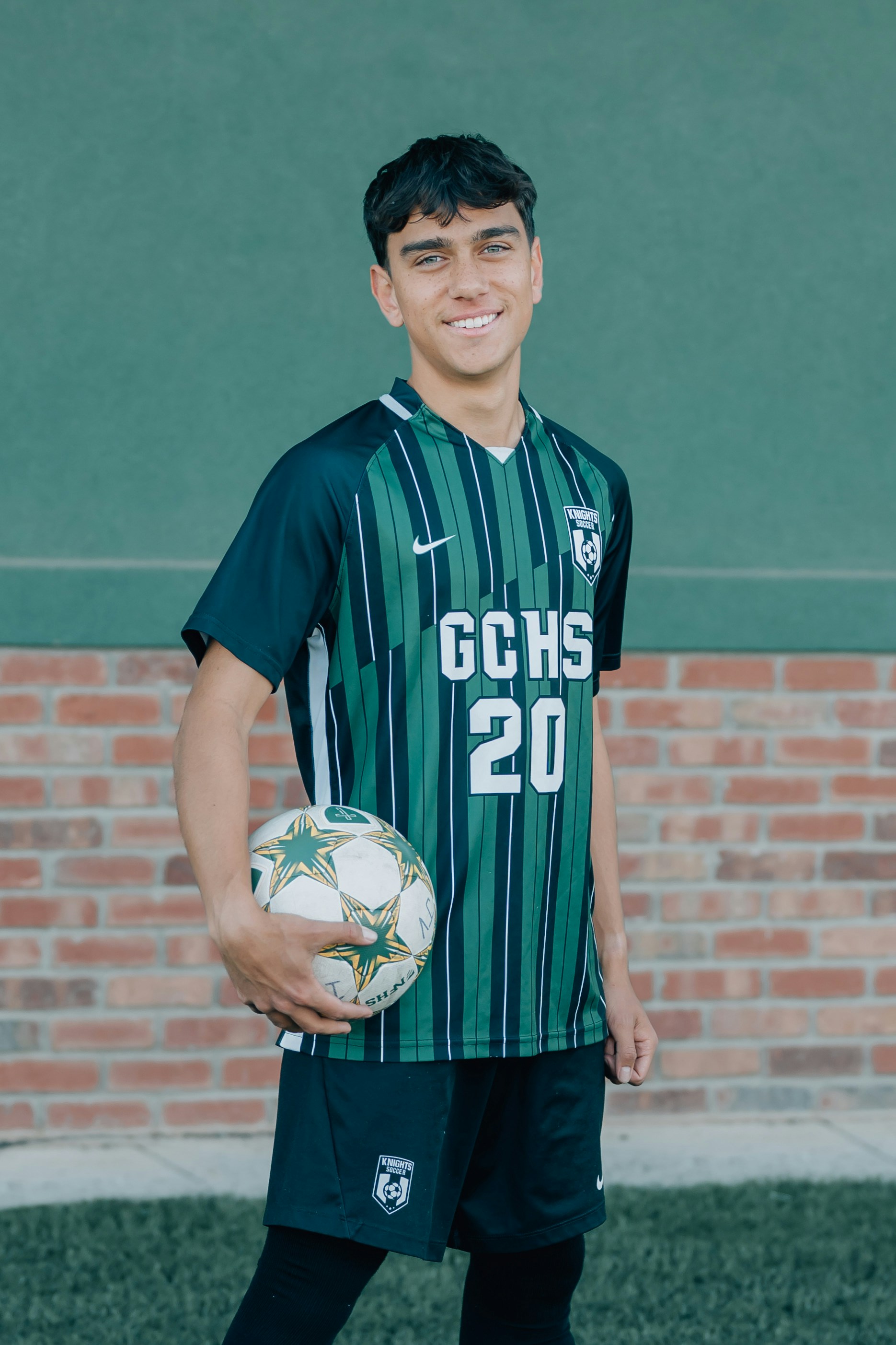 Portrait of a Young Soccer Player with a Ball Against a Brick Wall