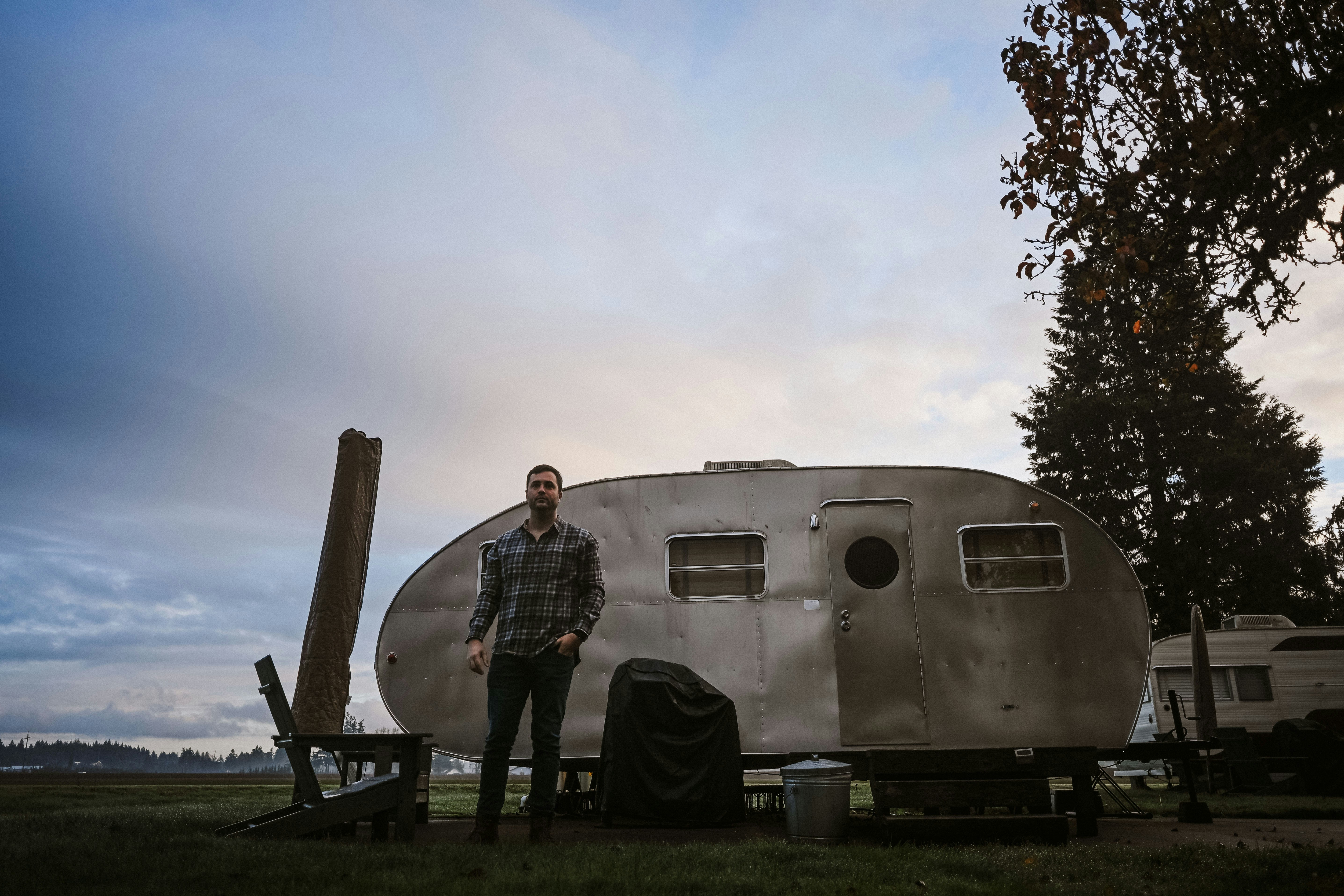 Man by a Vintage Camper Under a Wide Sky
