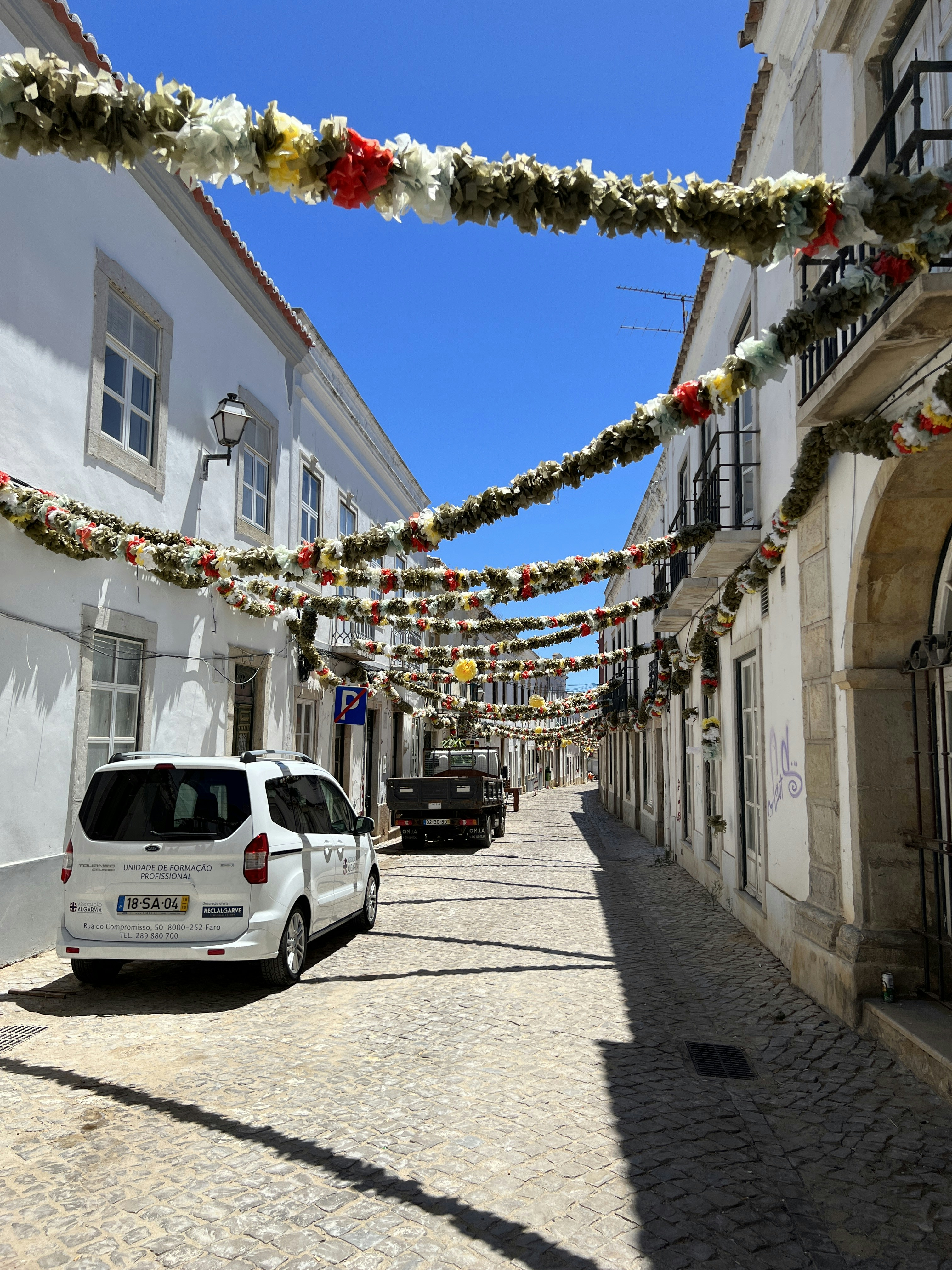 Sun-Threaded Lane: festive garlands over a sunlit Portuguese street