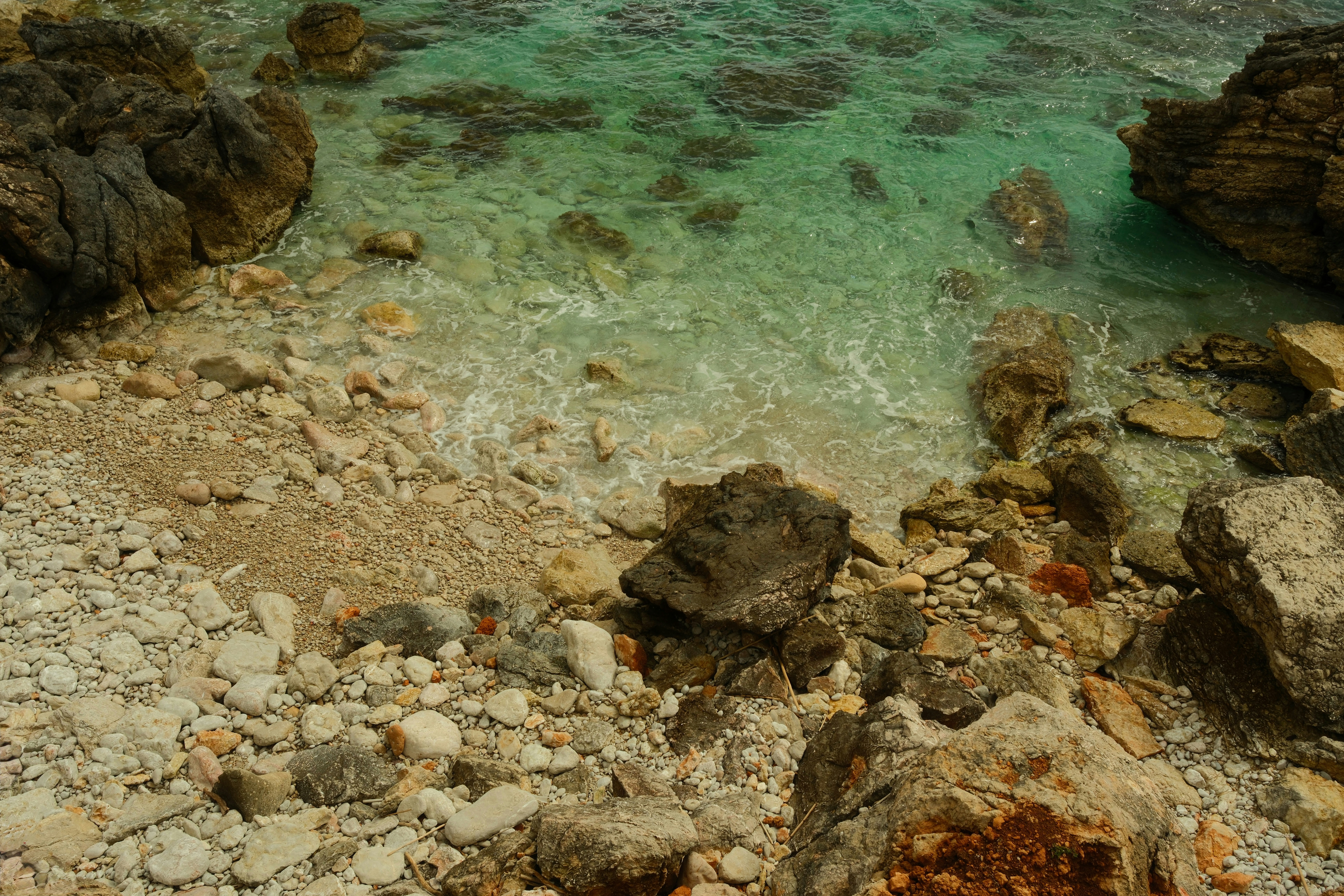 Emerald Edges: Craggy Shoreline Meeting Turquoise Tide
