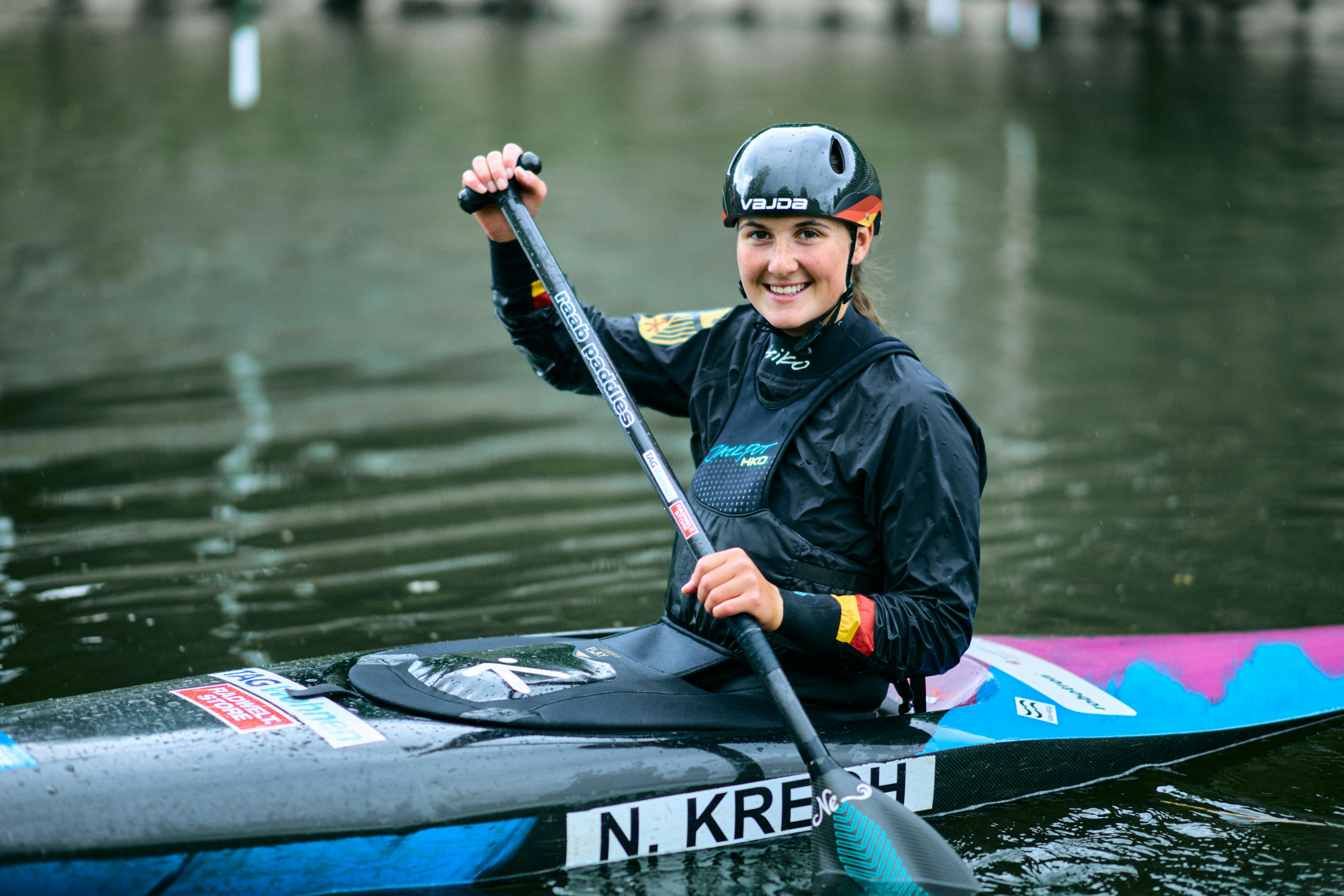 Smiling Kayaker Grips the Paddle, Ready for the Next Stroke