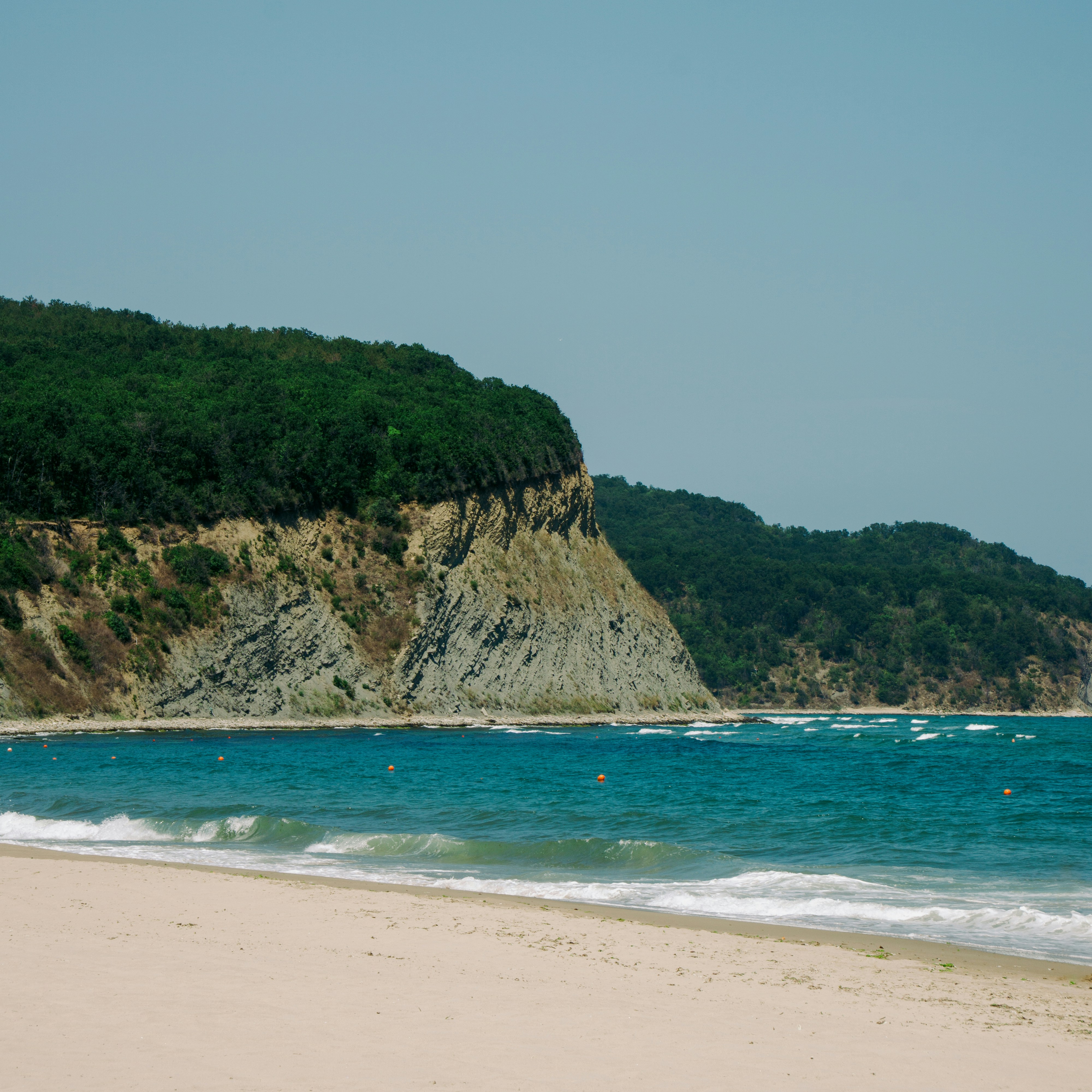 Cliffline Serenade: A Quiet Beach Beneath Green Slopes