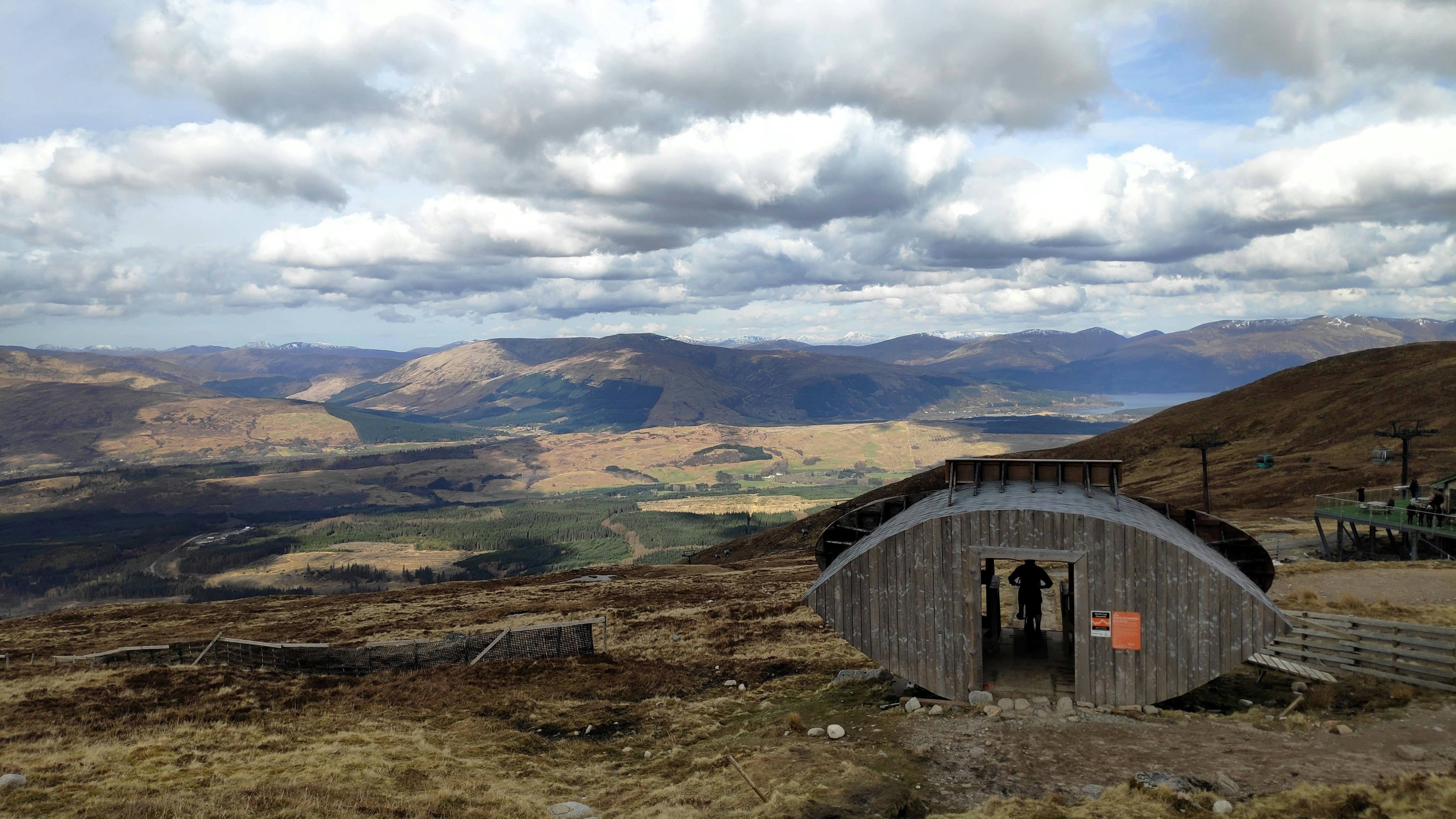 Hiker Portal: A Curved Wooden Entrance Framing a Vast Mountain Panorama