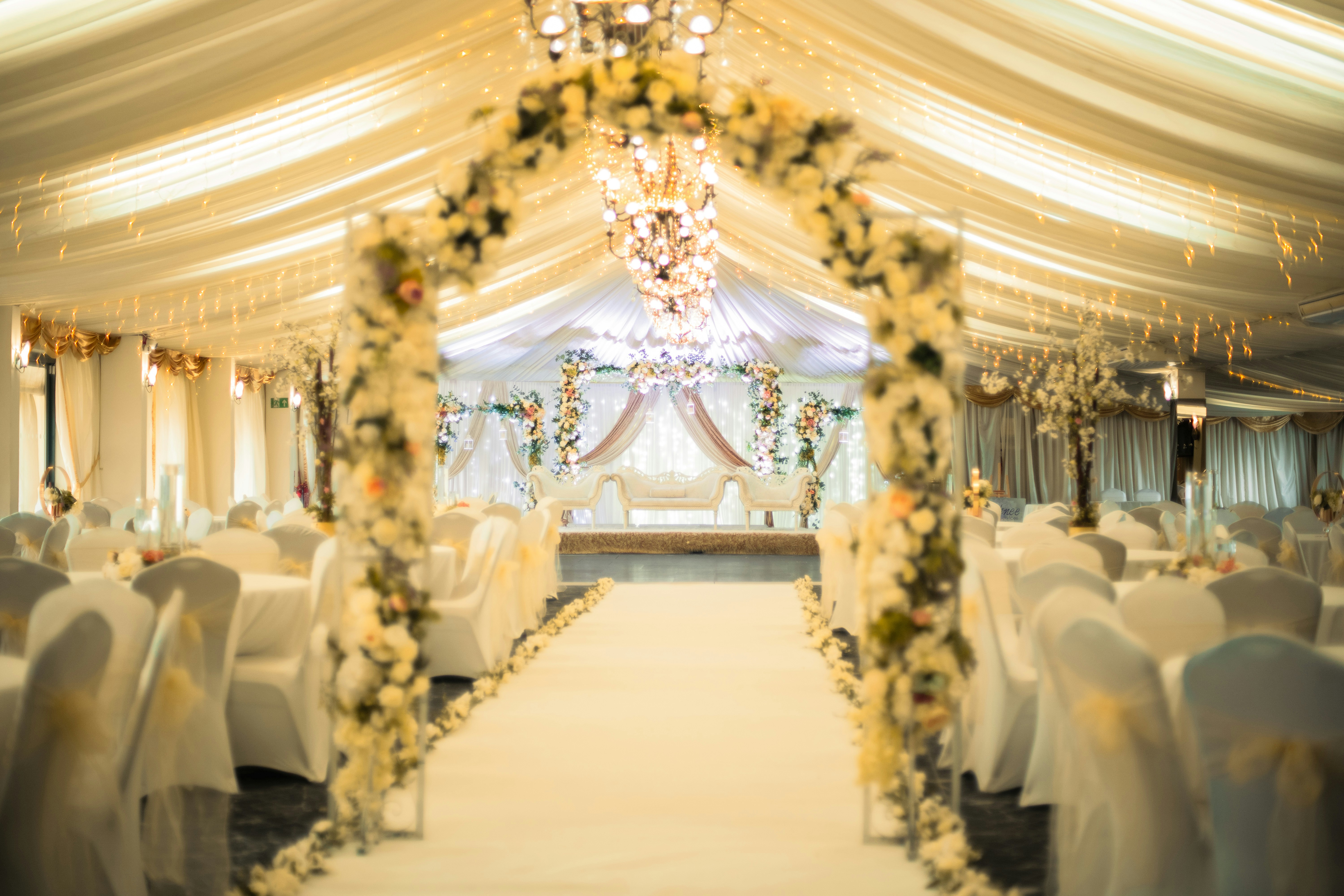 Elegant wedding reception hall with floral archway and white decor ...