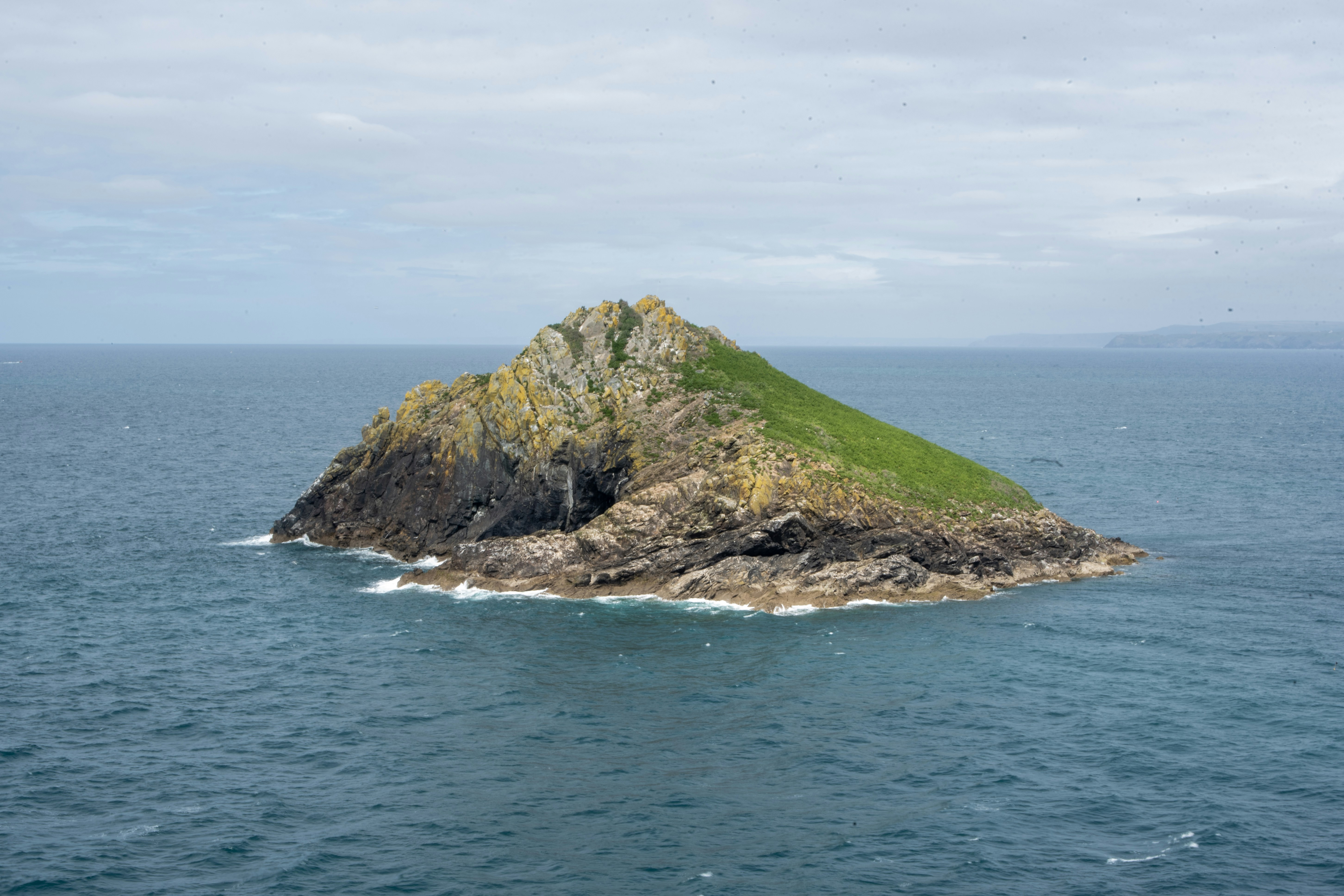 Altar of the Sea: A Green-Capped Islet Rising from Blue Depths