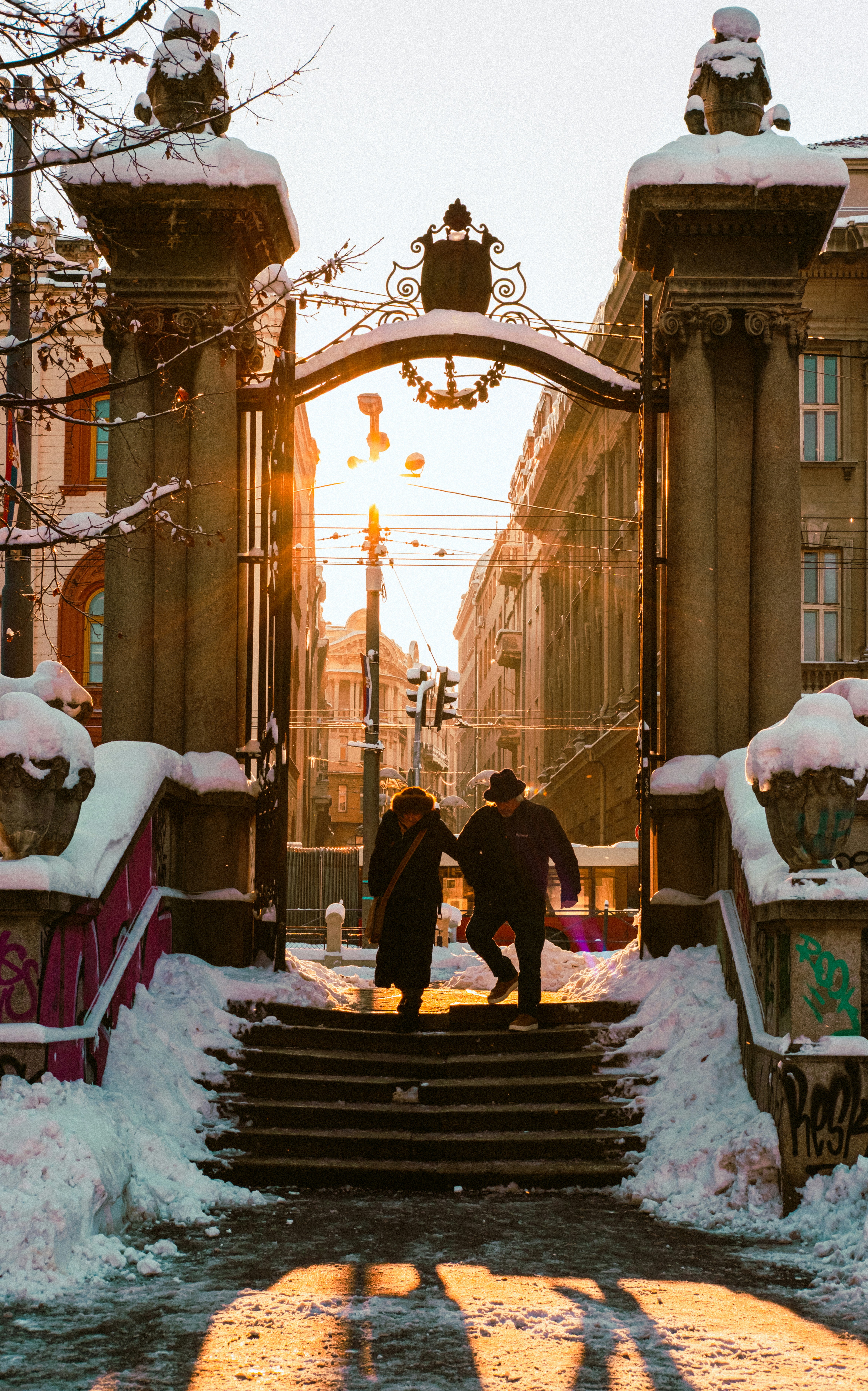 Sunlit Gateway: Lovers Descend the Snow-Blanketed Steps