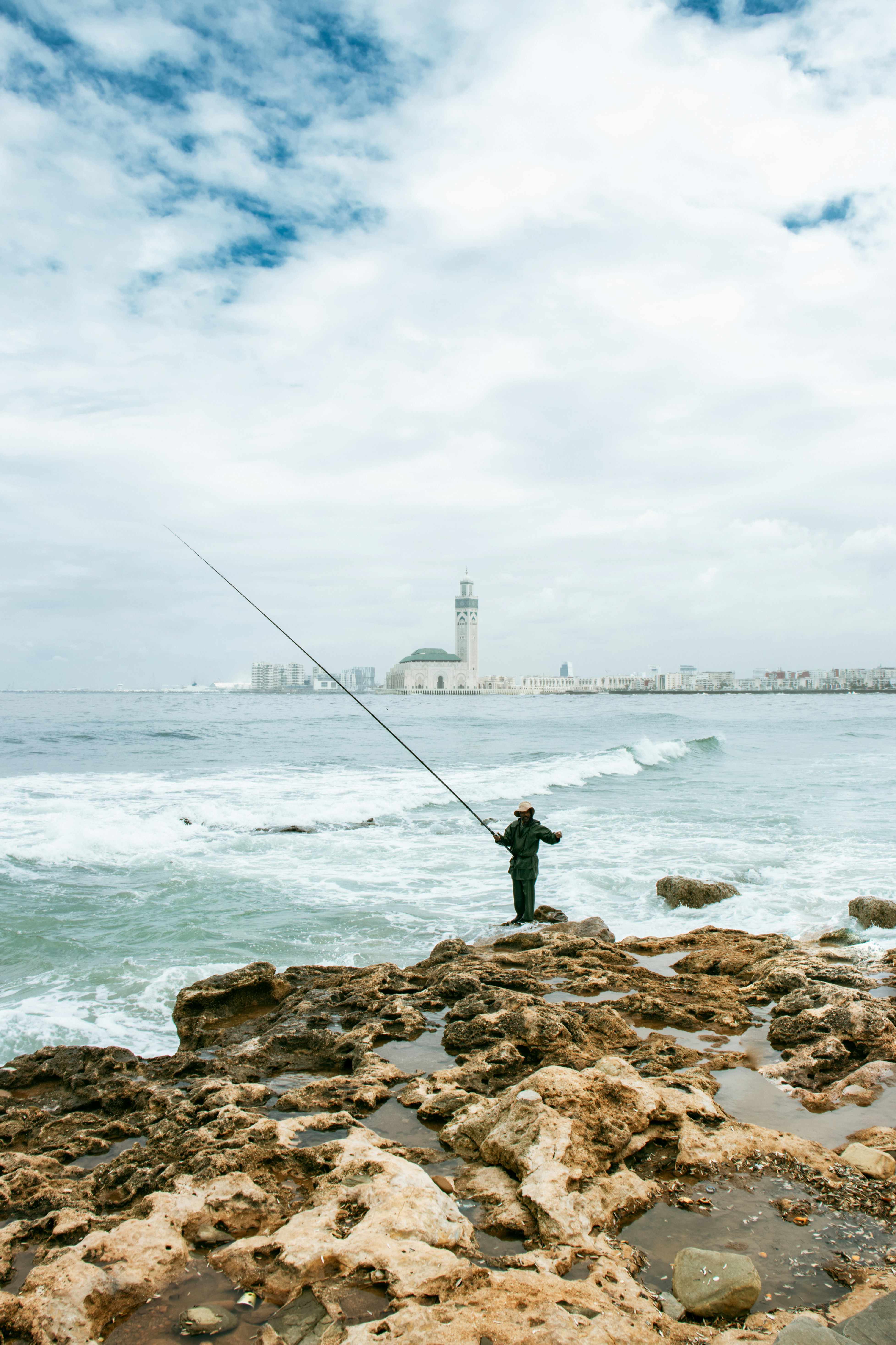 Ridge and Rod: A Lone Angler Casts Toward the Harbor of Dawn