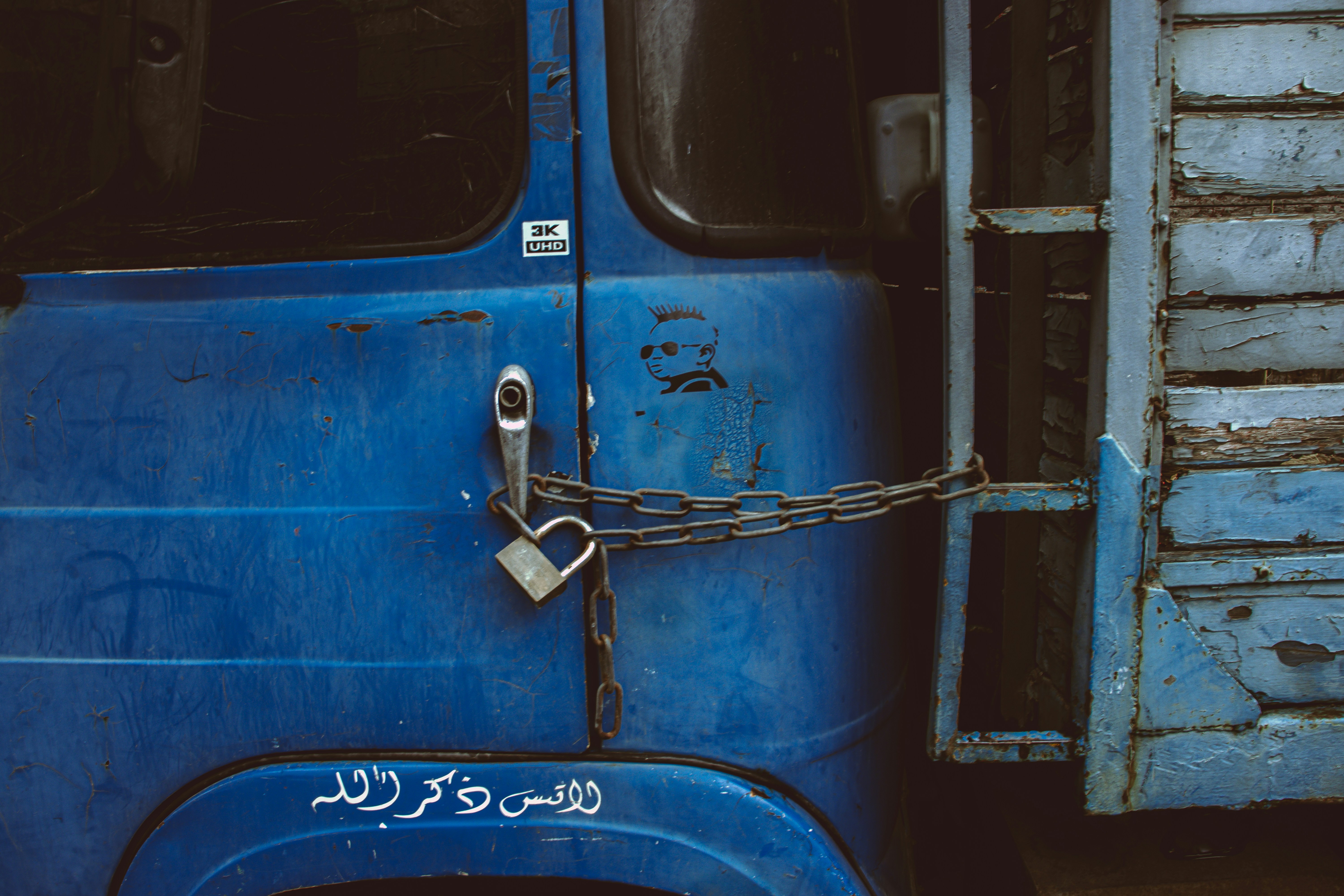 Locked in Blue: A Timeless Chain on a Weathered Truck Door