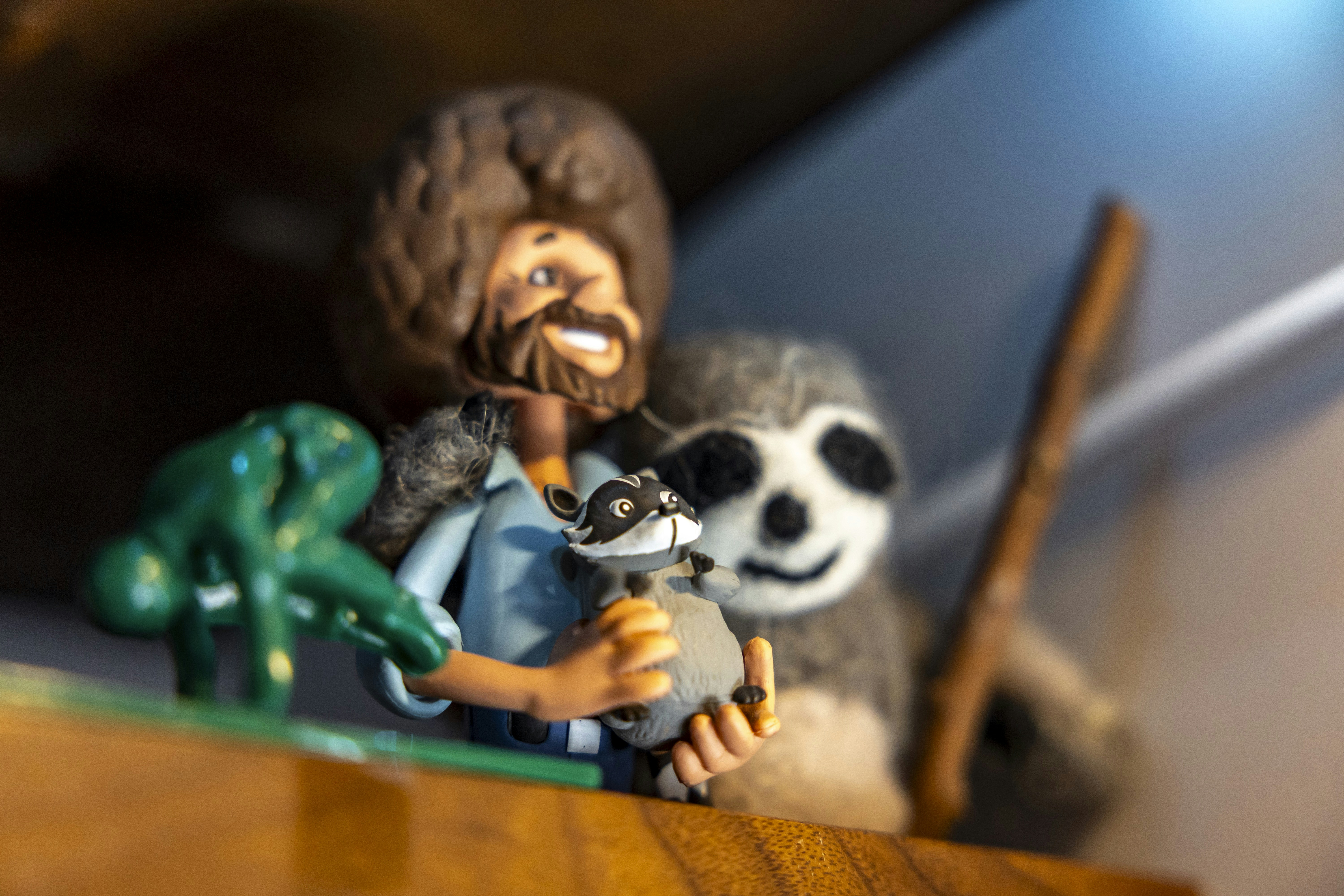 Dramatic Toy Scene: Bearded Explorer, Sloth, and Tiny Friend Under Studio Light