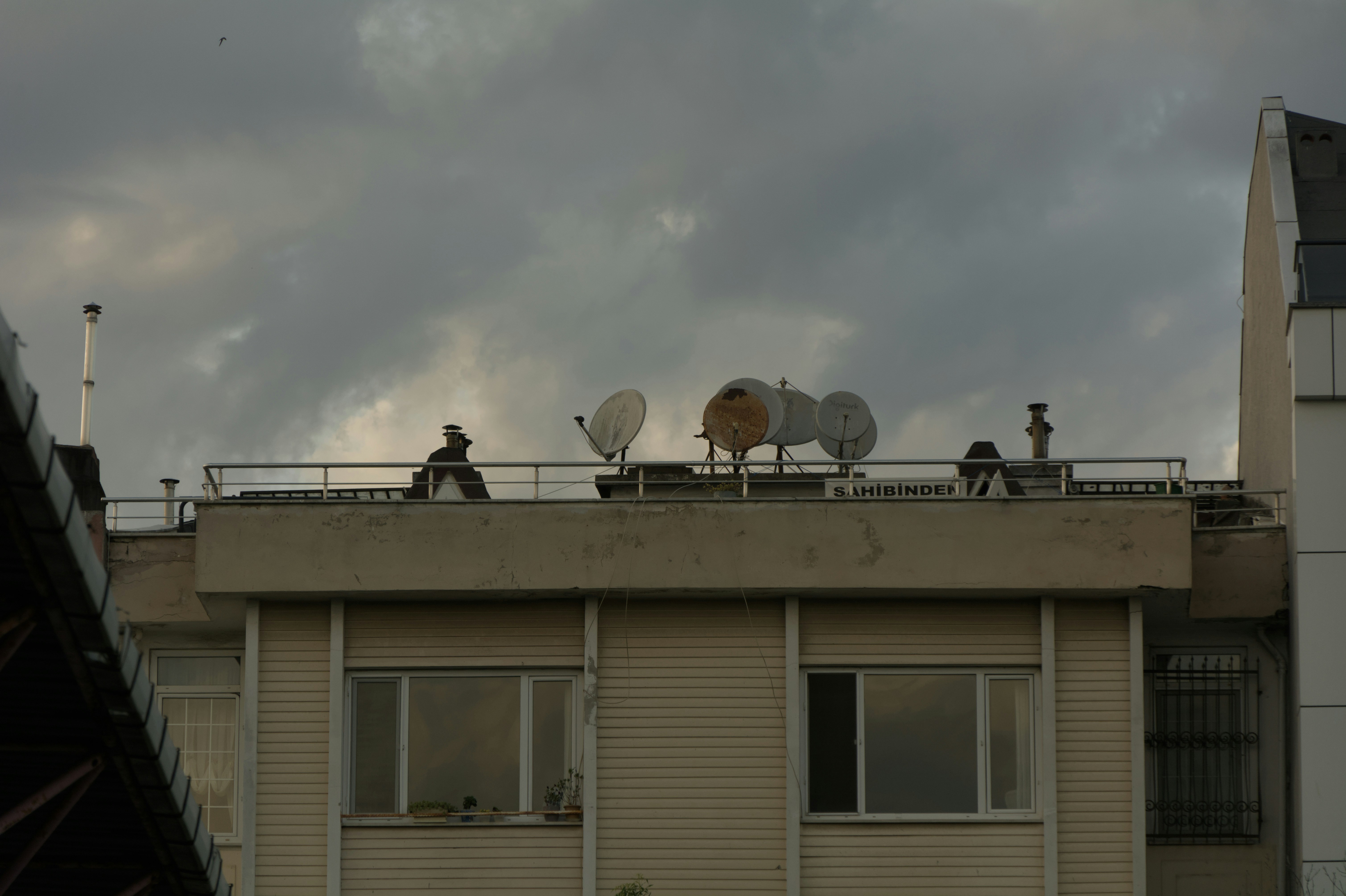 Rooftop Satellite Array Under Ominous Sky