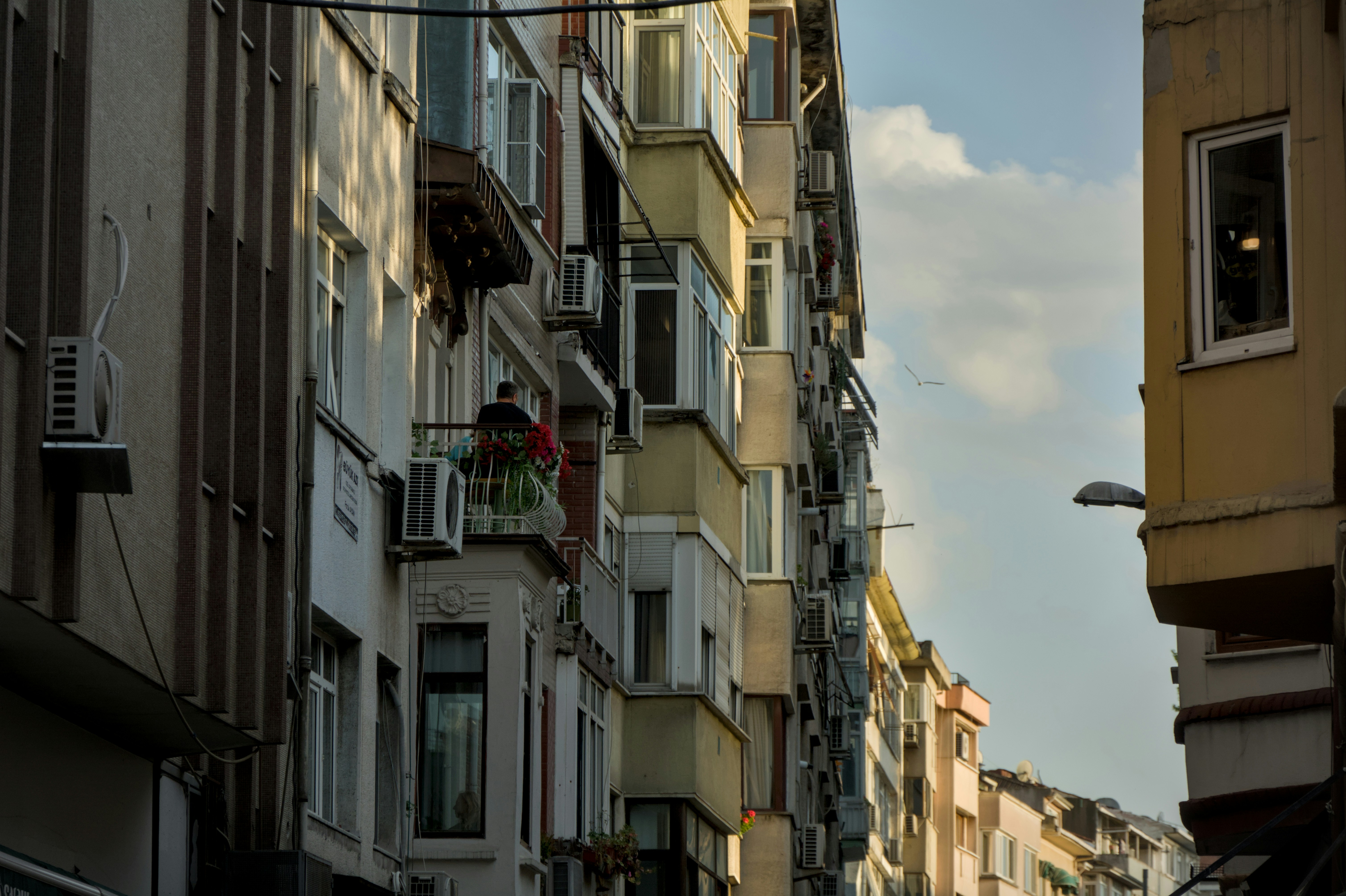 Urban Facade Corridor with Sunlit Windows and Distant Sky
