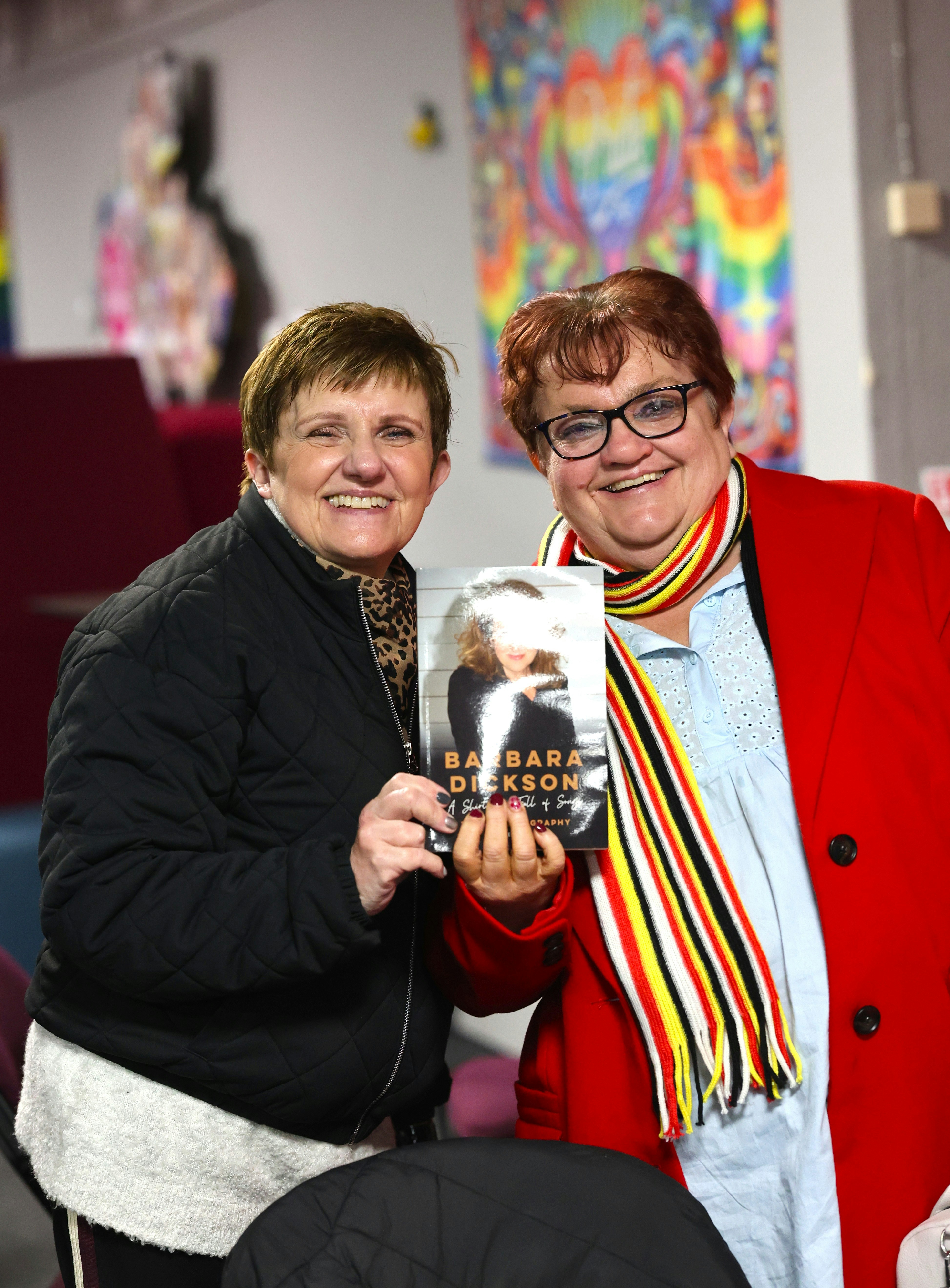 Smiling Duo with a Book: A Moment of Shared Pride