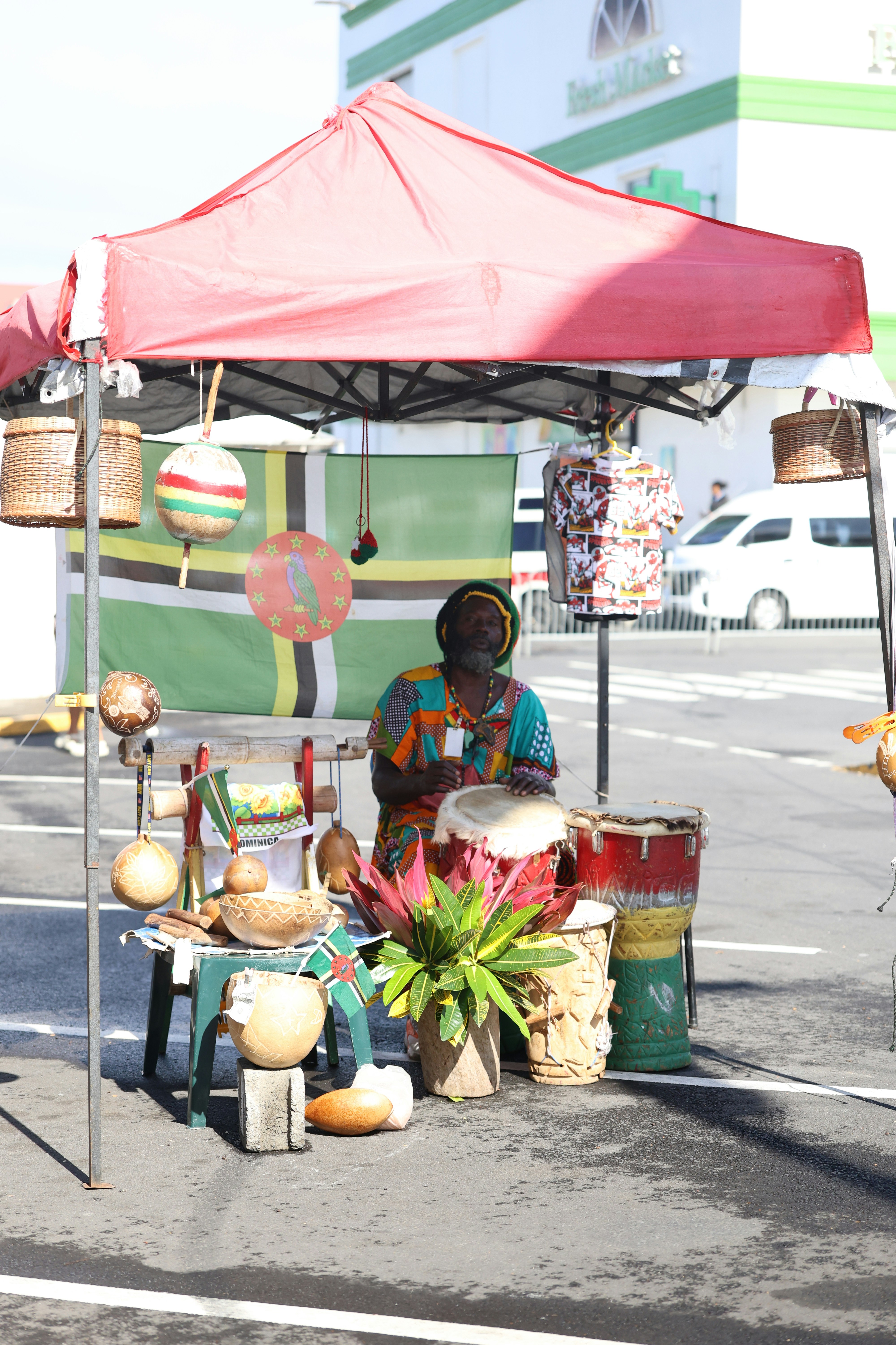 Street Vendor Under a Red Tent: Drums, Gourds, and Colorful Attire
