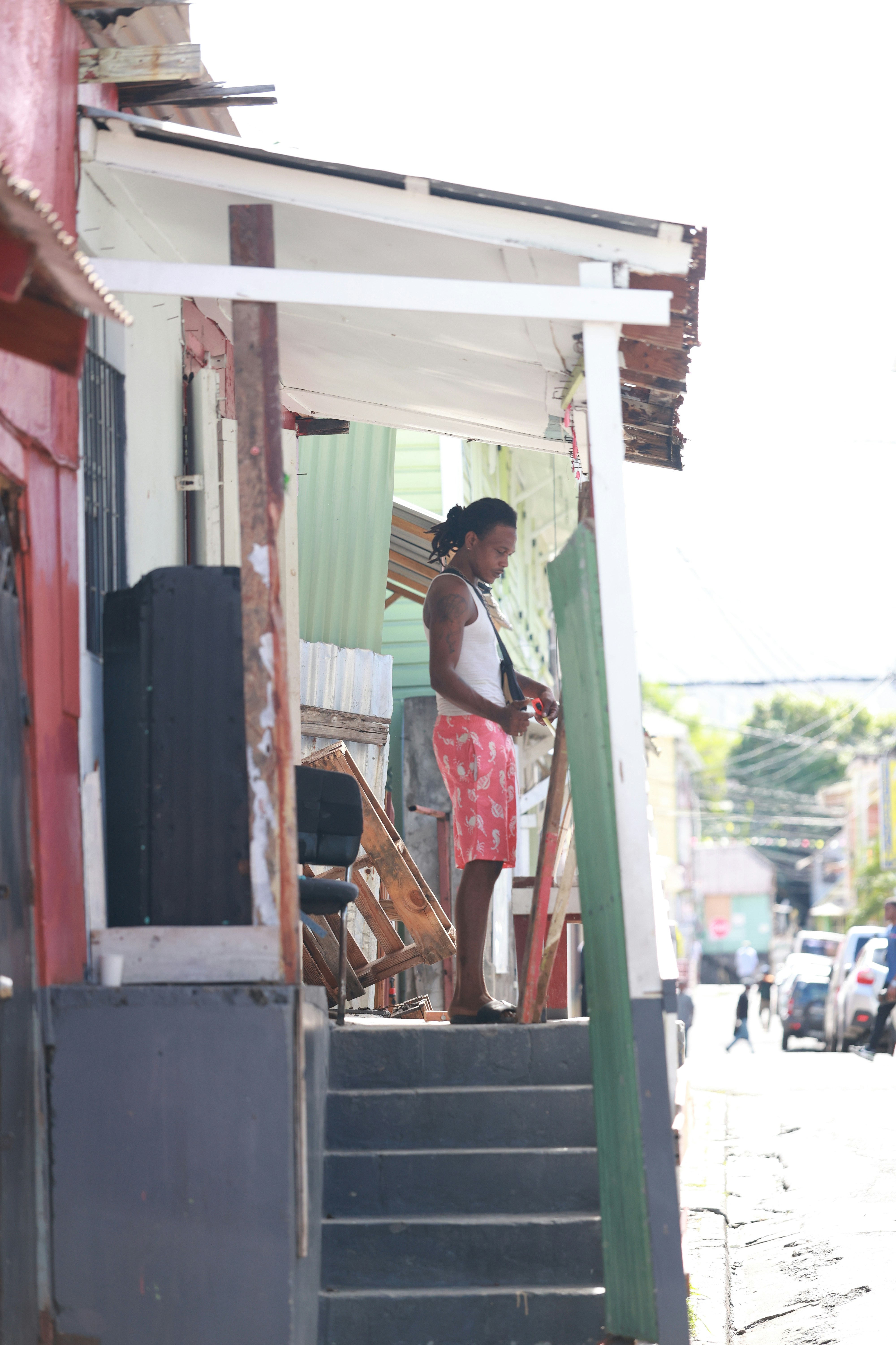 Portrait on the Porch: A Quiet Moment on a Caribbean Street