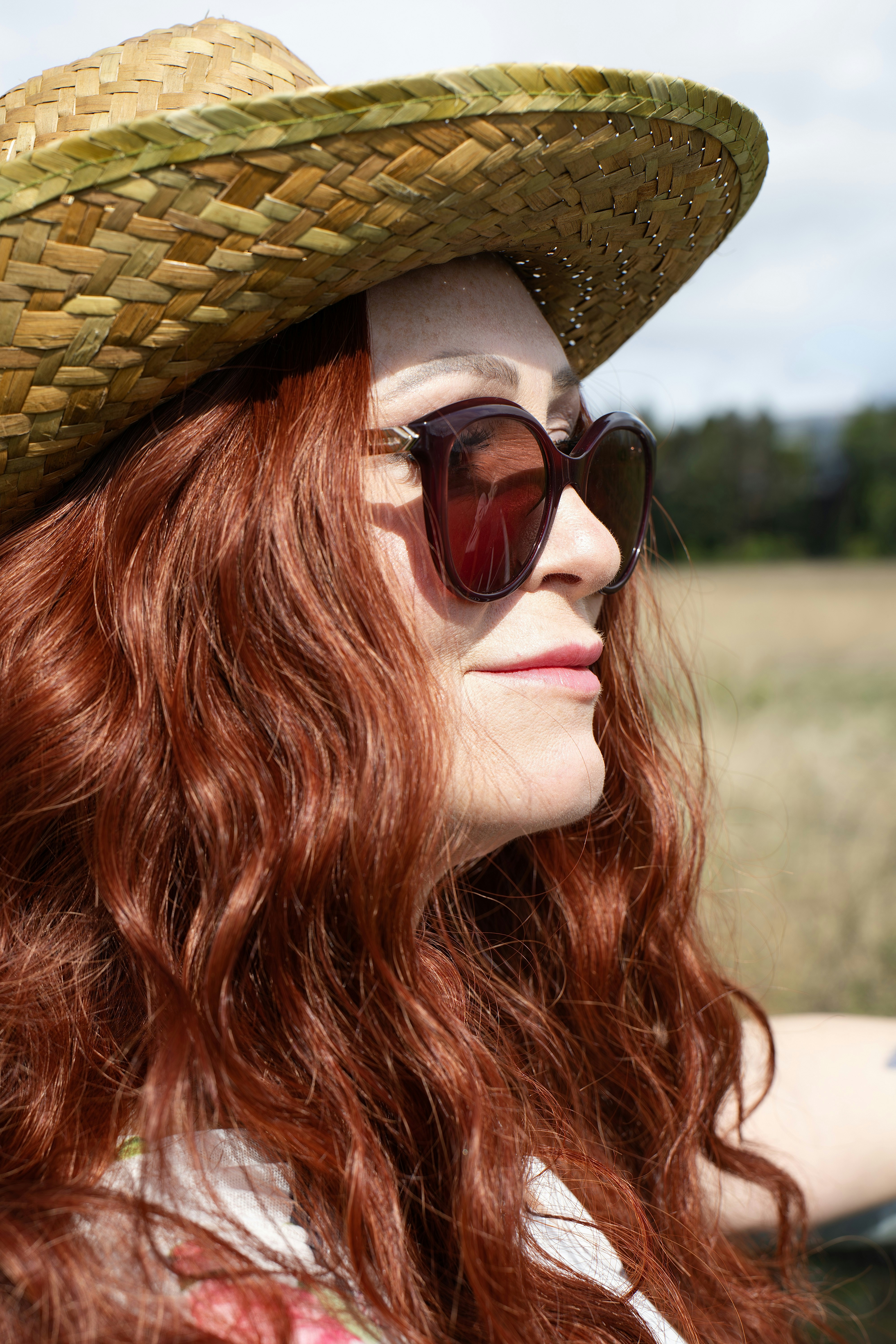 Sunlit Red Locks and Straw Hat: A Stroll in Warm Focus