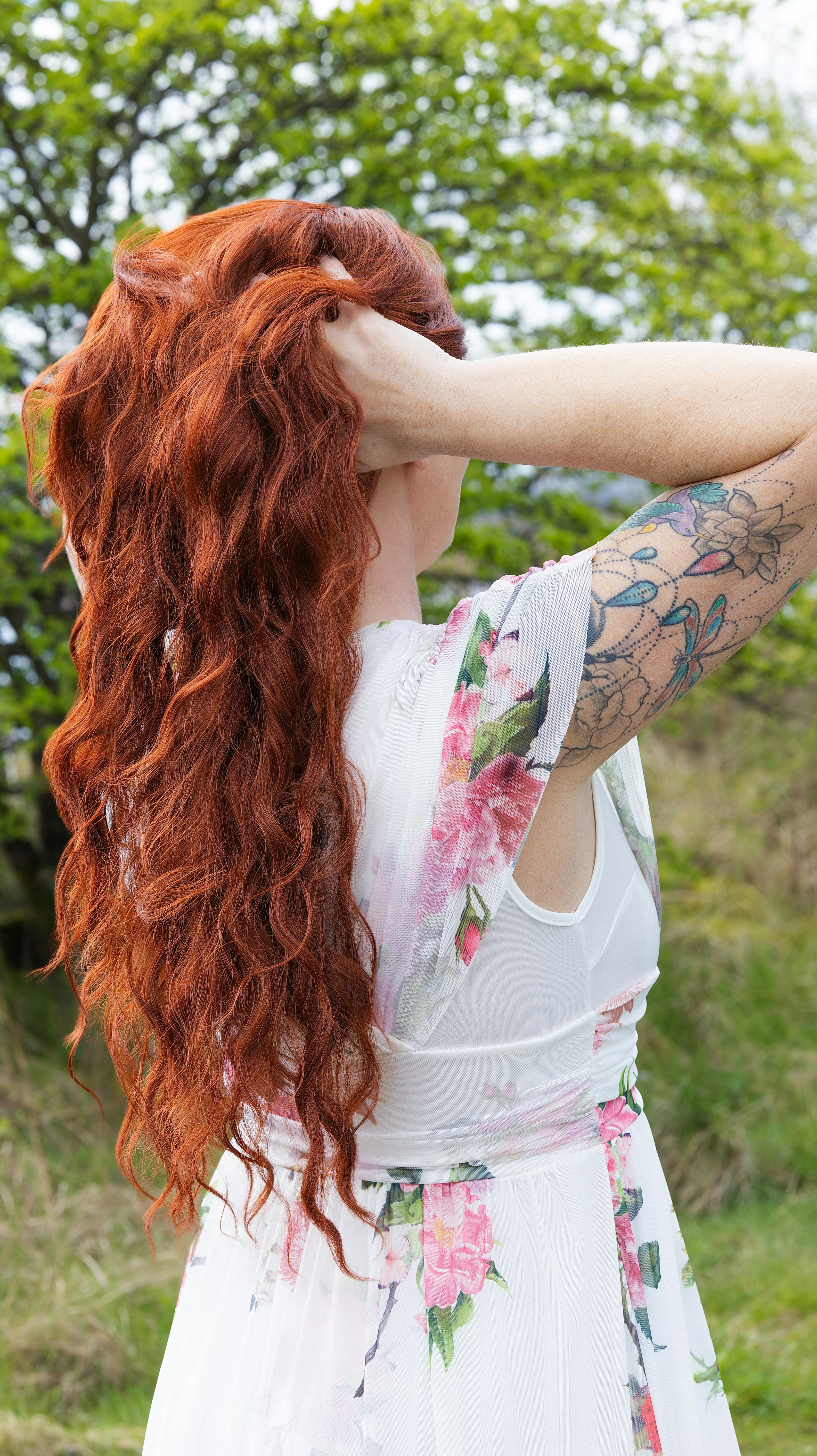 Vibrant Reds and Floral Veil: Portrait in a Green Retreat
