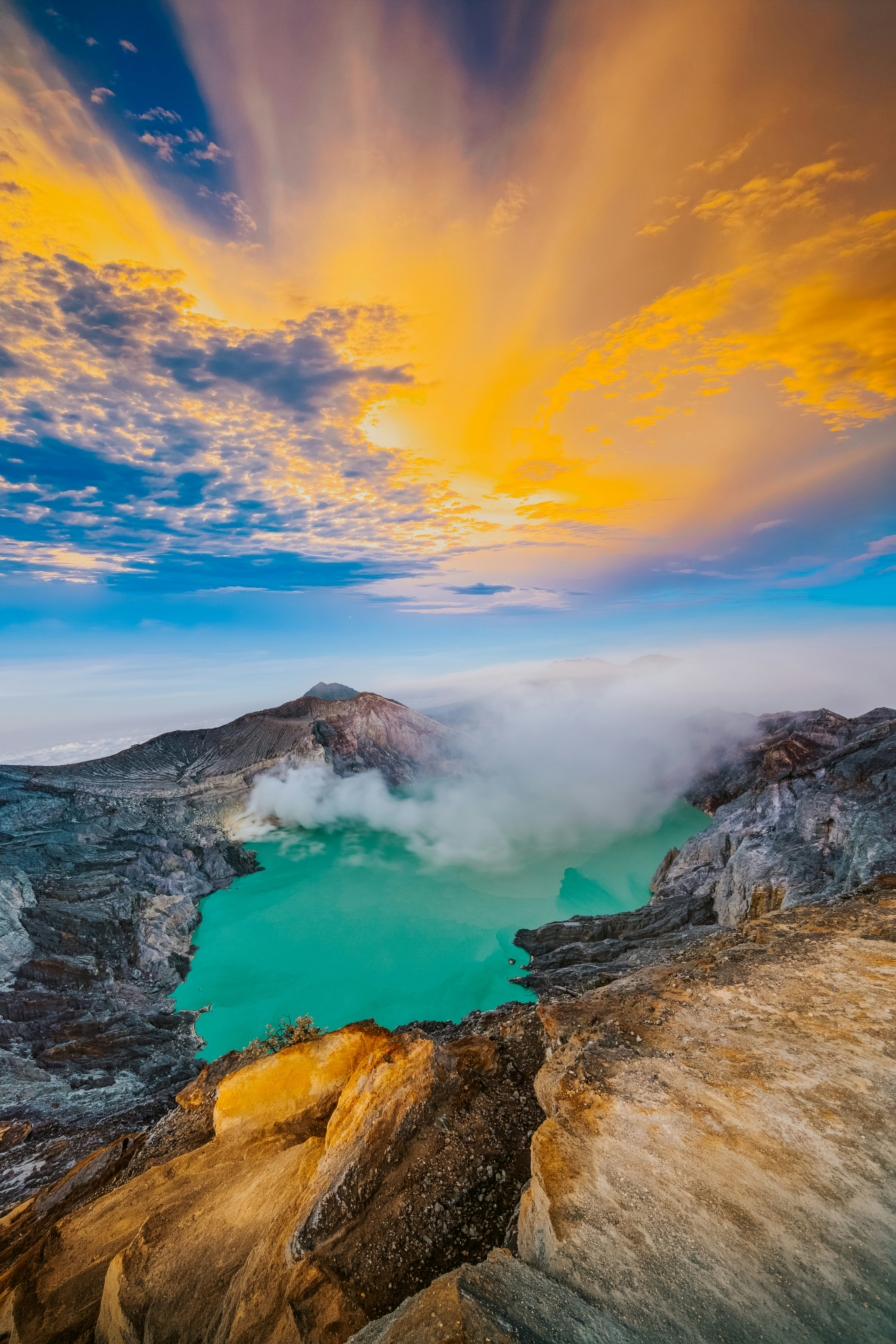 Emerald Crater at Dawn: Clouds Uncurl Over a Sulfuric Lake